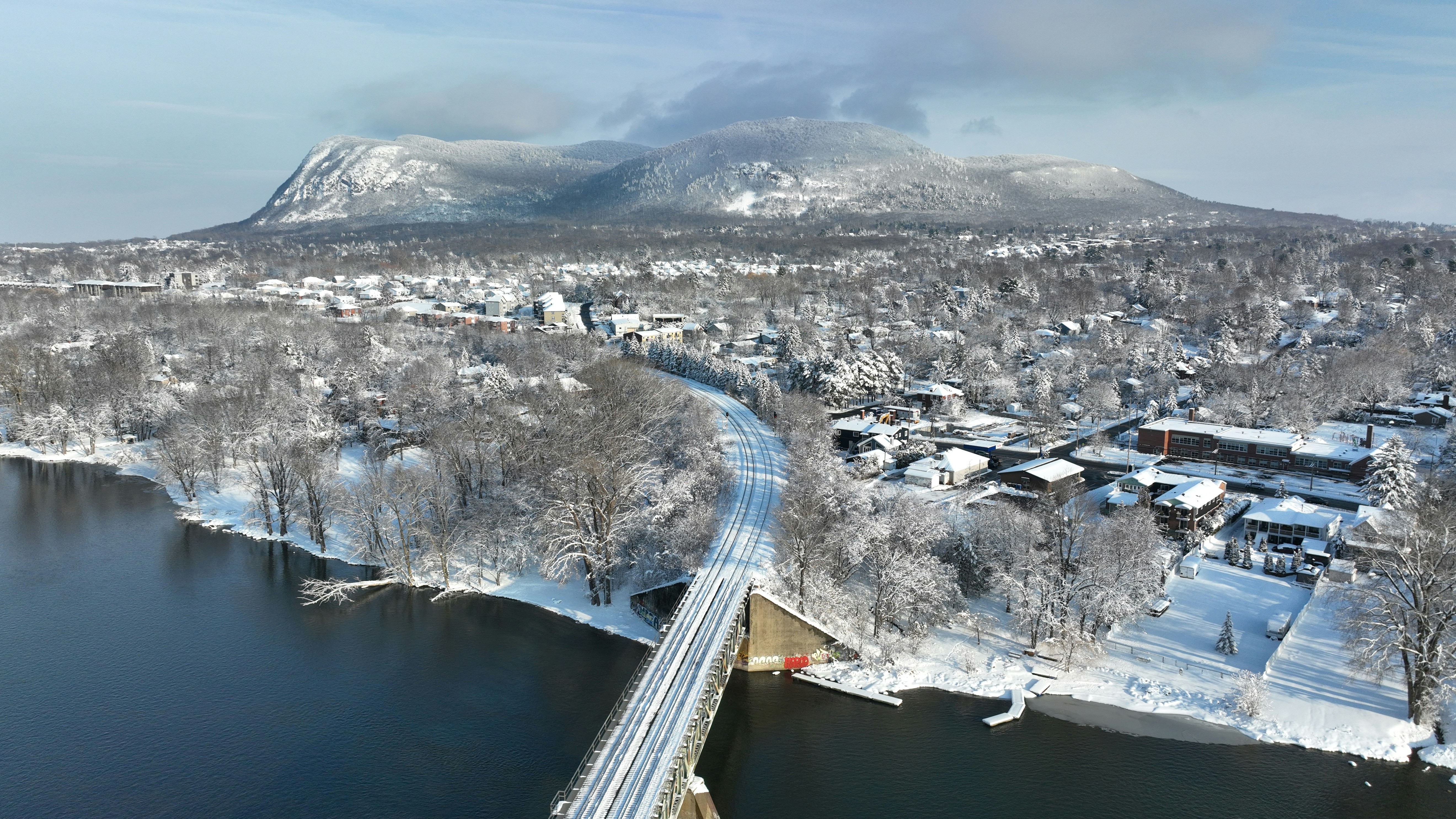 Frost-Wrapped Viaduct Framing a Snowbound Village by a Frozen River