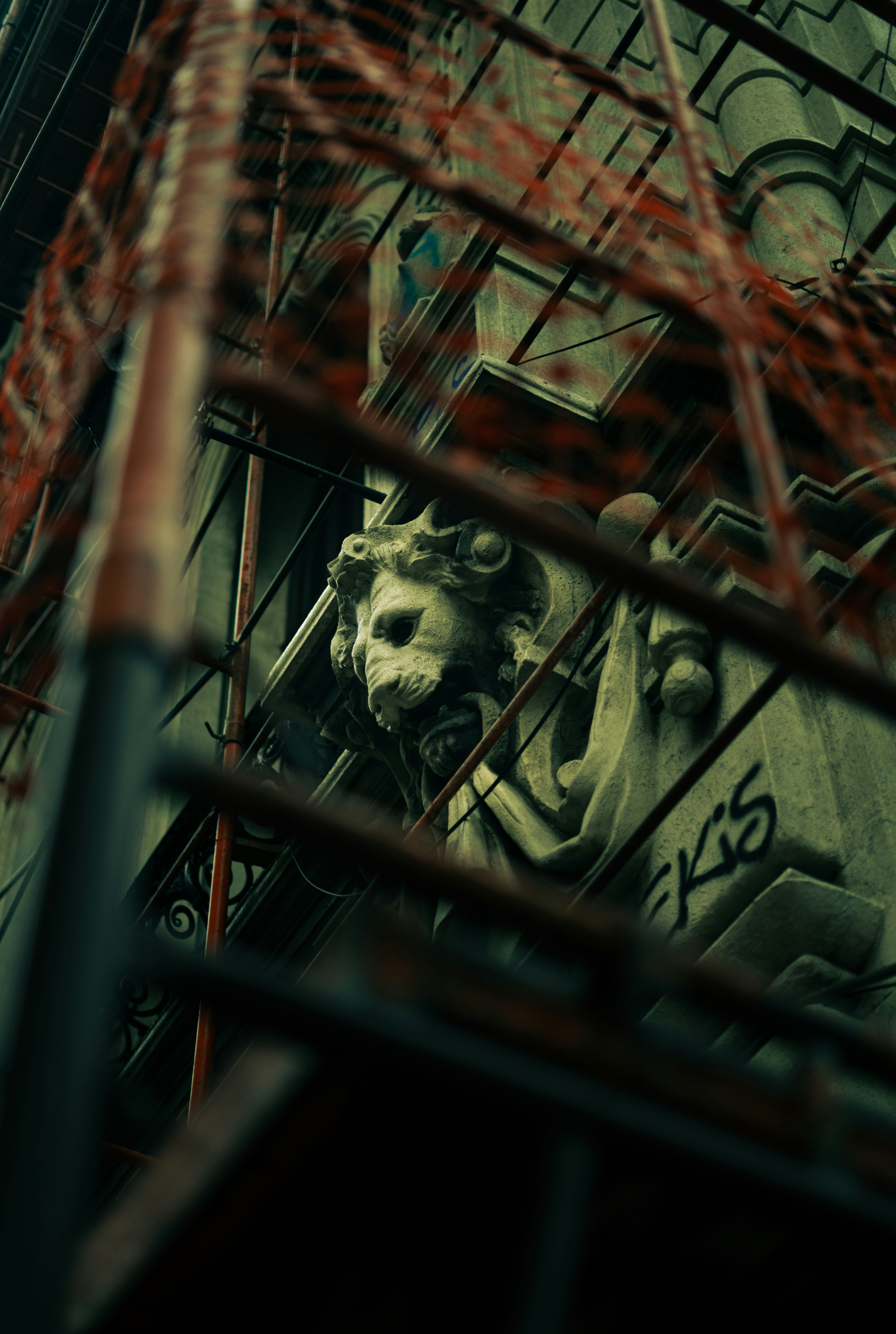 Hidden Guardian Among Red Veils: The Stone Lion Peering Through Scaffolding
