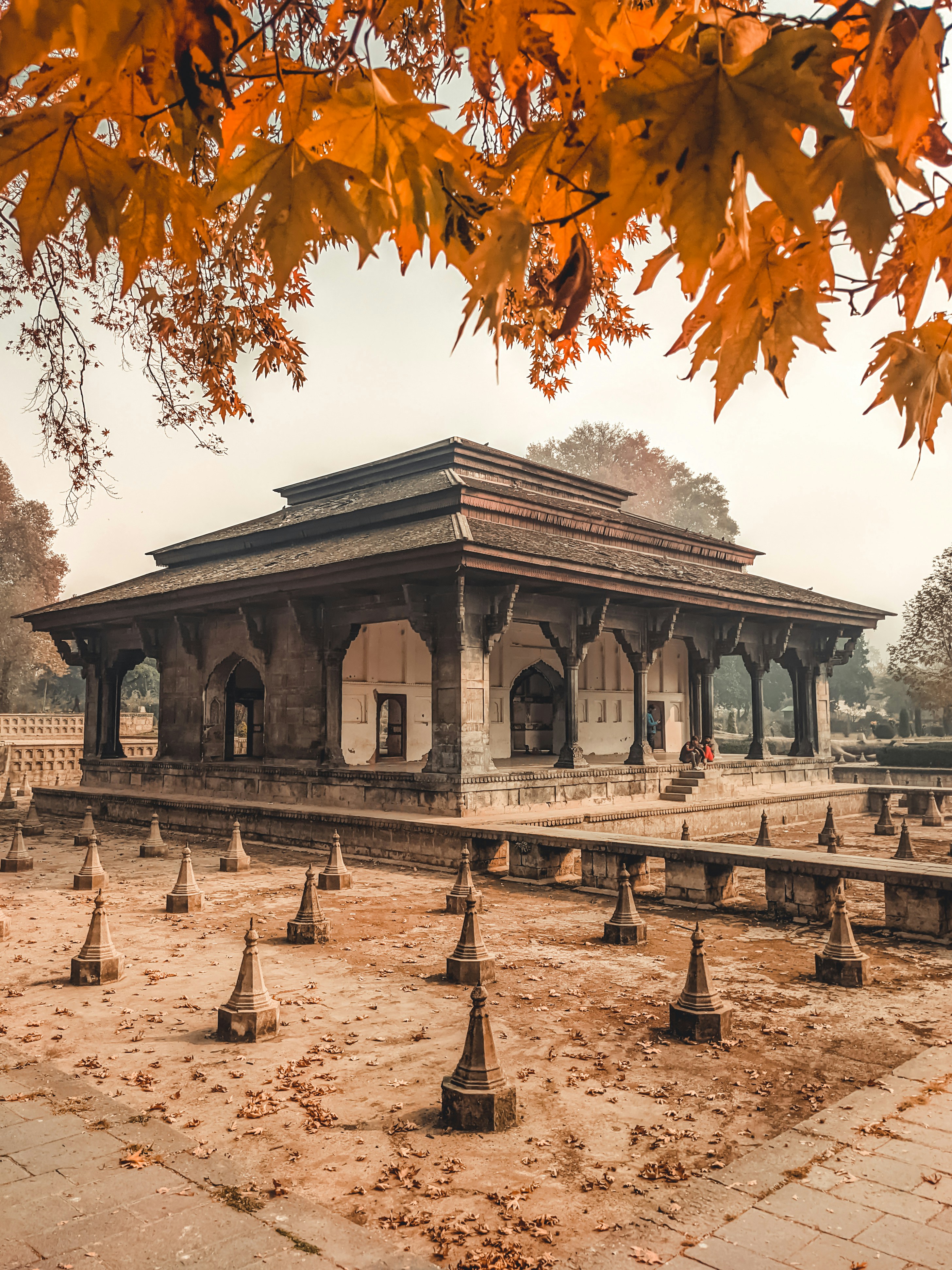 Crimson Canopy Over a Timeless Stone Pavilion