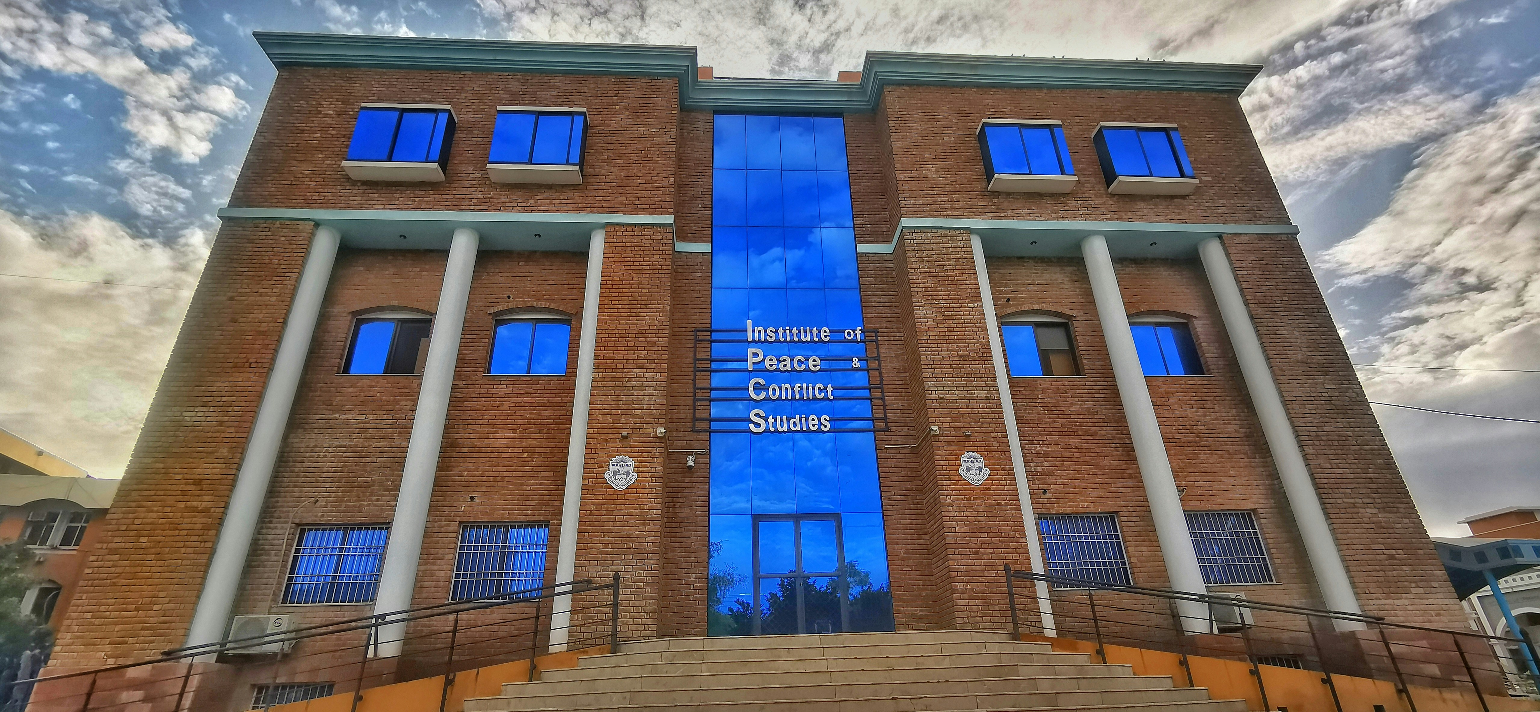 Blue Glass Gateway: A Symmetrical Brick Campus Building with a Central Glass Atrium