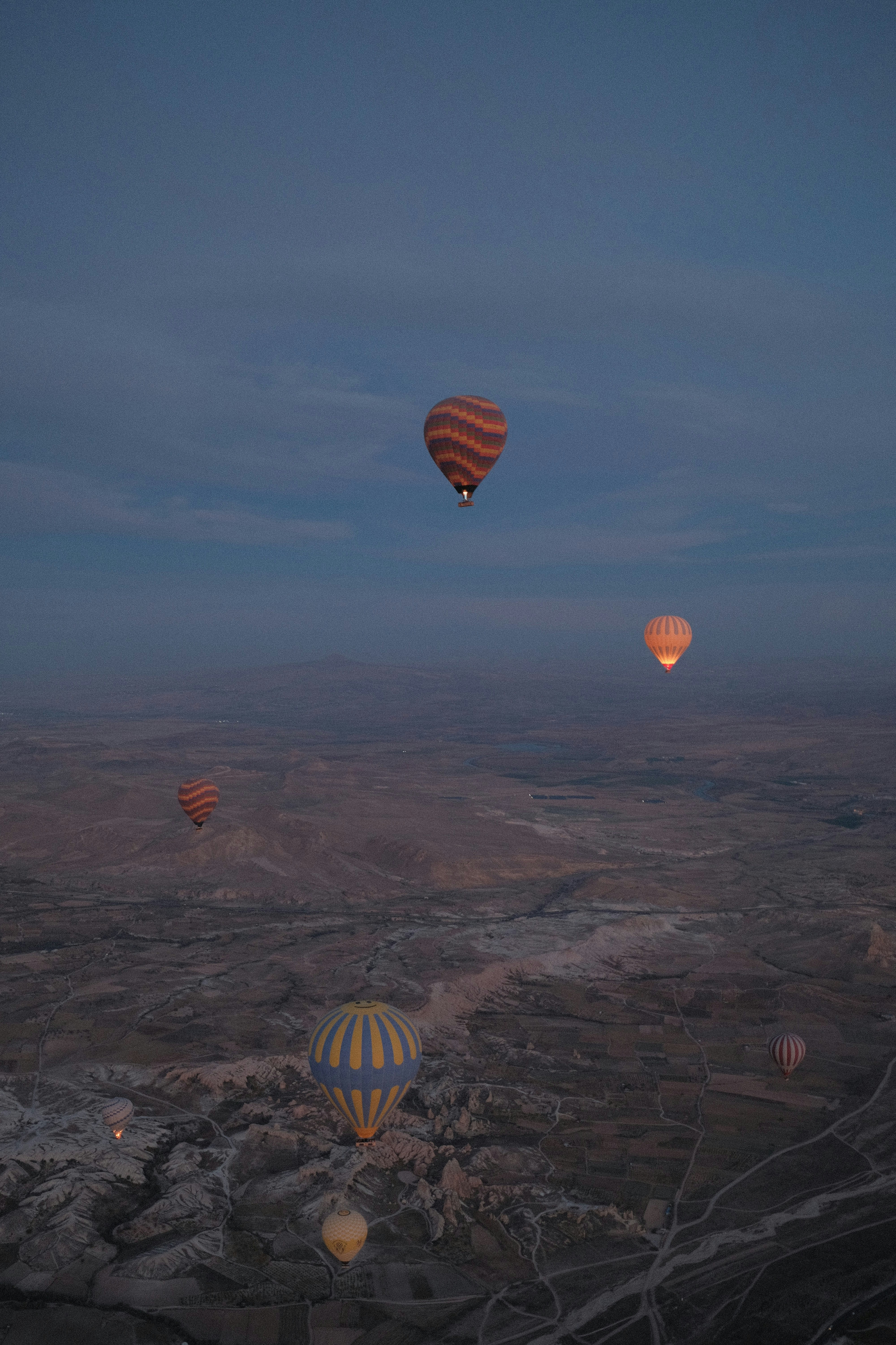 Echoes of the Sky: Three Balloons Drifting Above the Desert Terrain