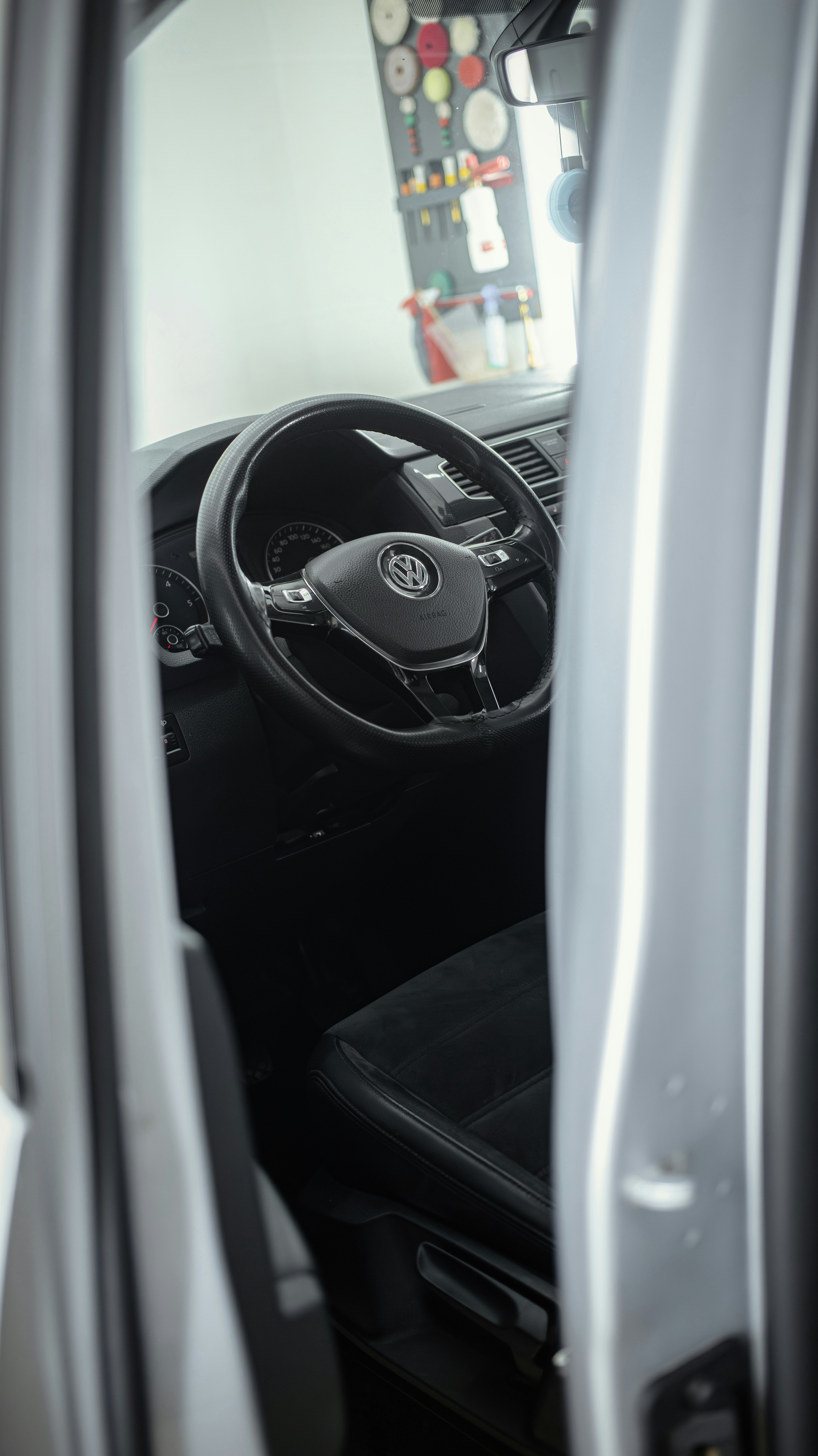 VW Cockpit in Frame: A Garage Workshop Portrait Through the Open Car Door