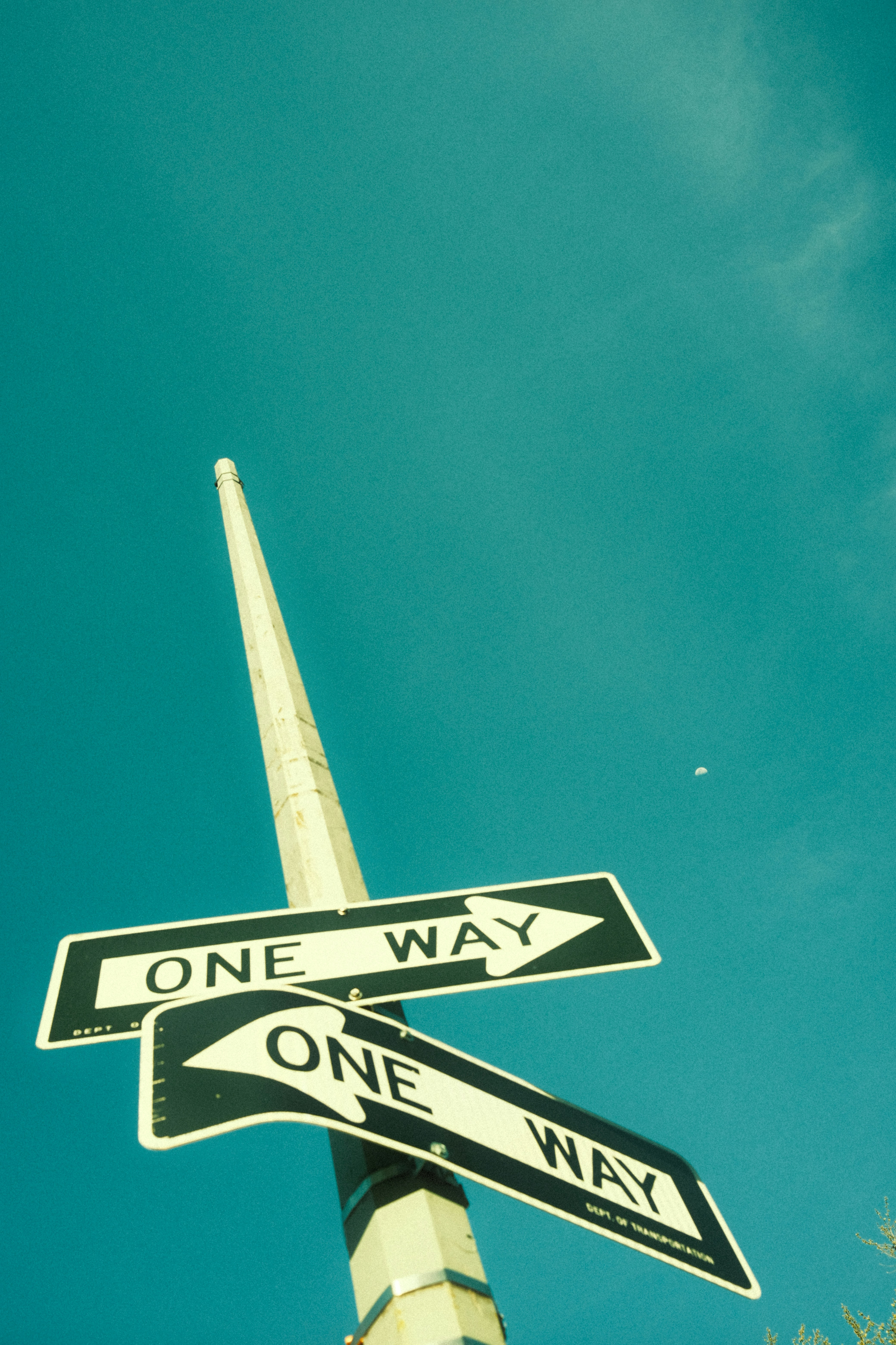 Two street signs on a pole with a blue sky in the background photo ...