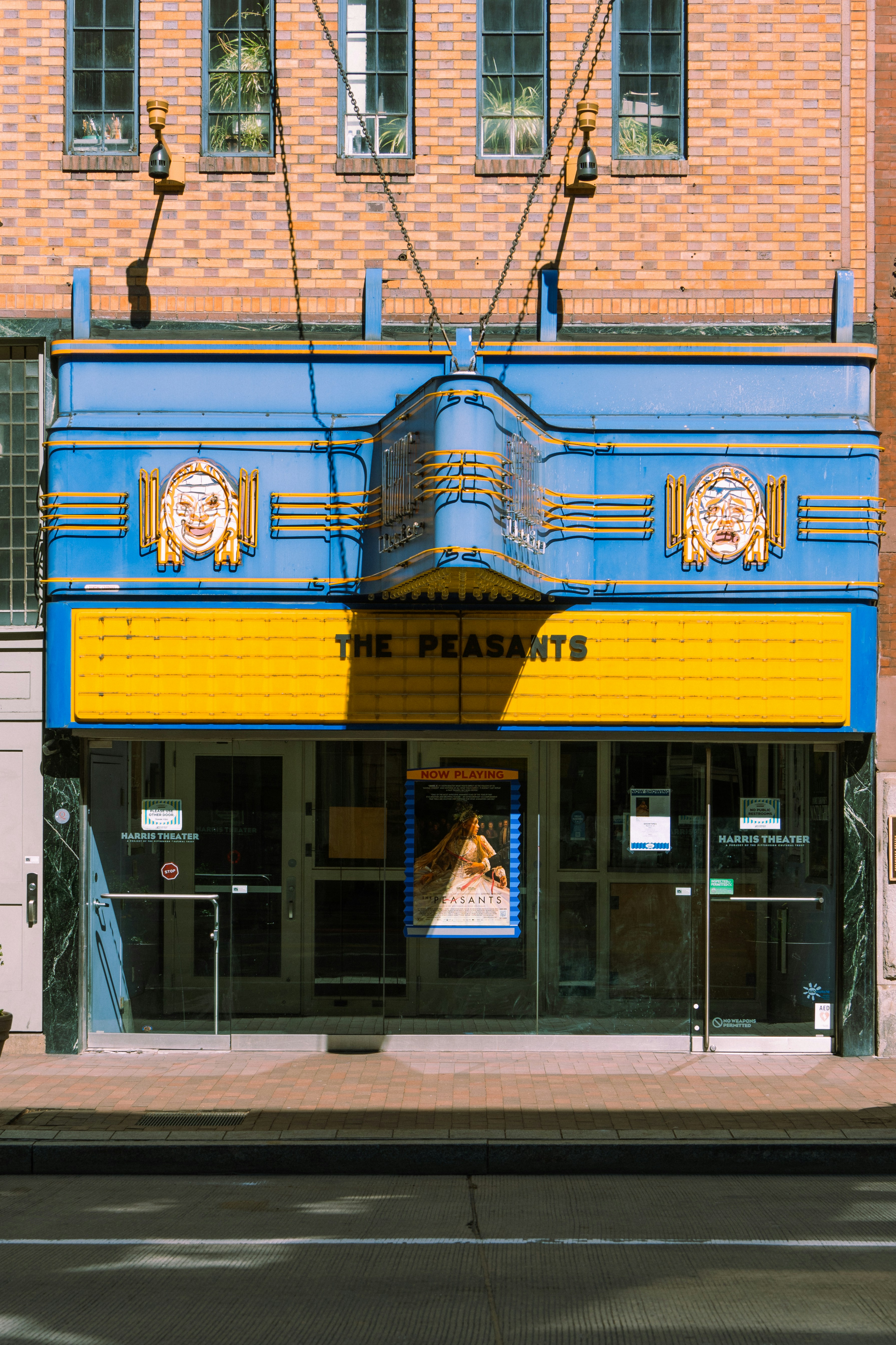 Neon Yellow Pedestal: The Peasants Theater Facade in Daylight