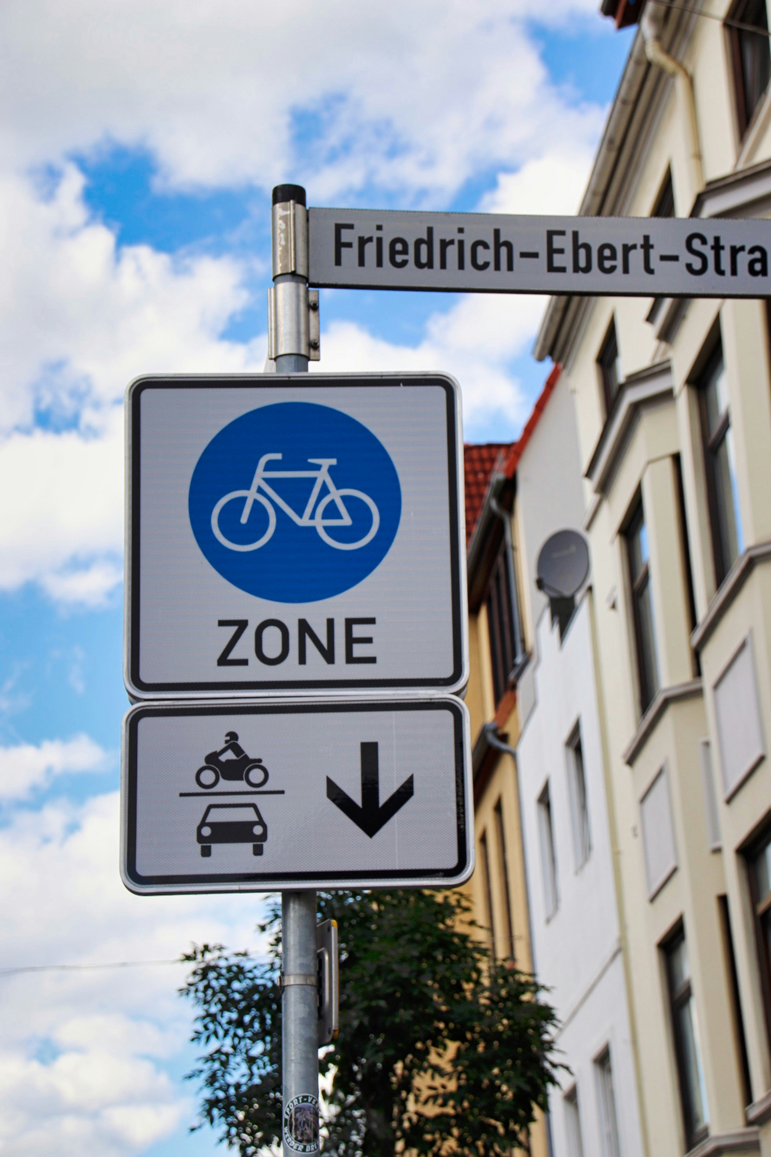 Blue Bicycle Zone Sign Framed by Narrow European Facades
