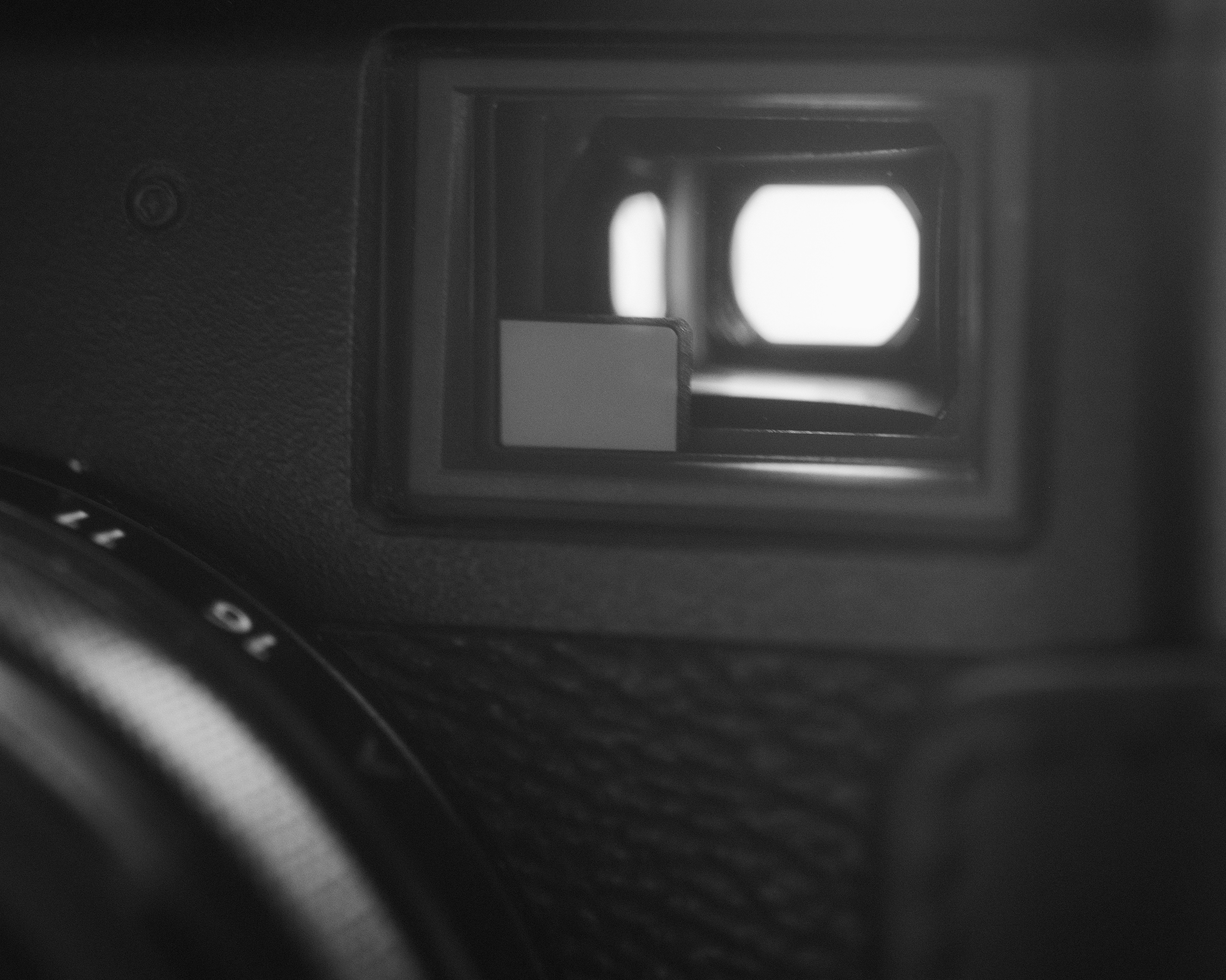 Close-up of the Fujifilm X100F hybrid viewfinder showcasing its complex optical design.