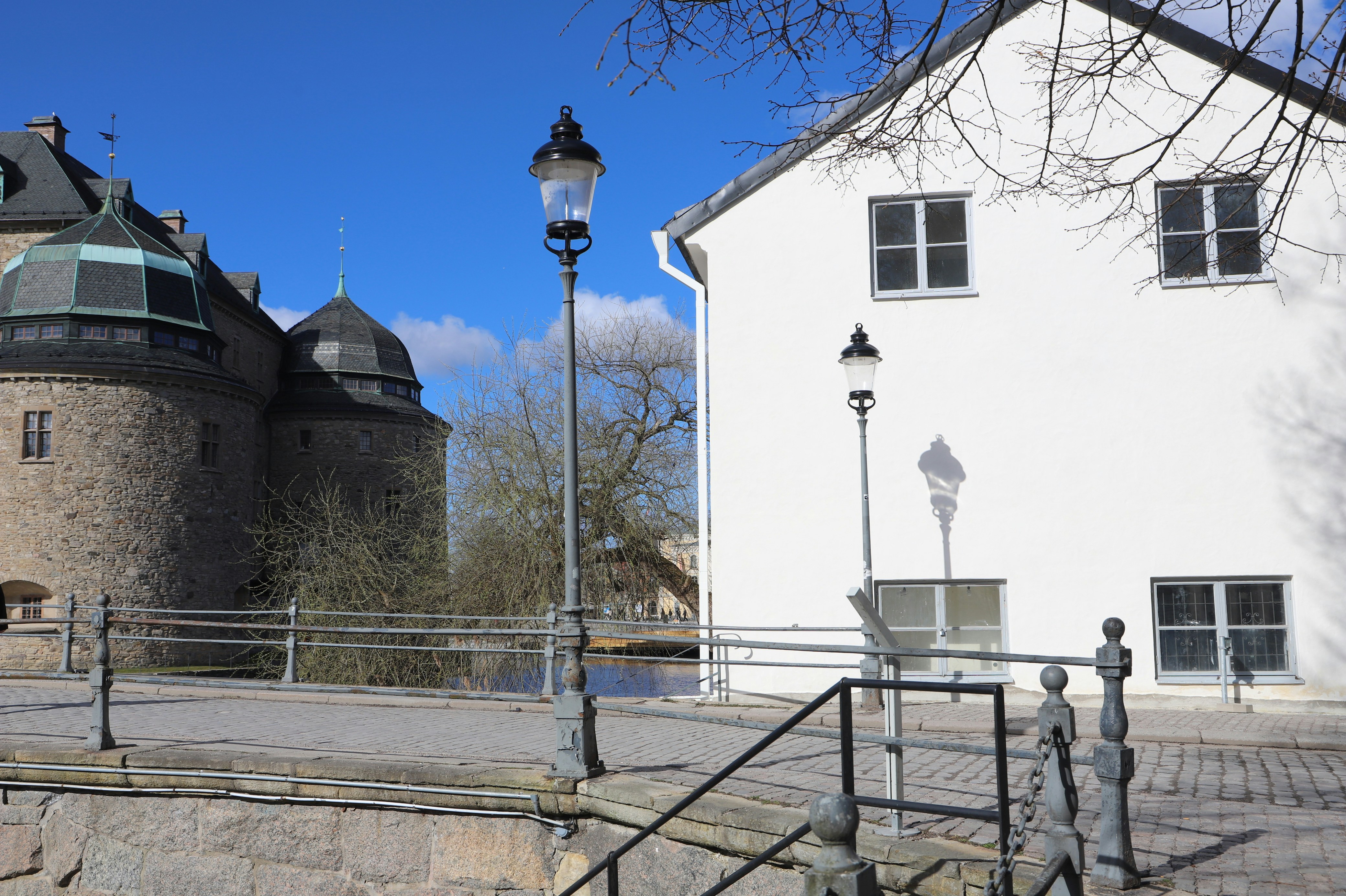 Riverside Geometry: White Facade, Stone Turret, and Vintage Lamps