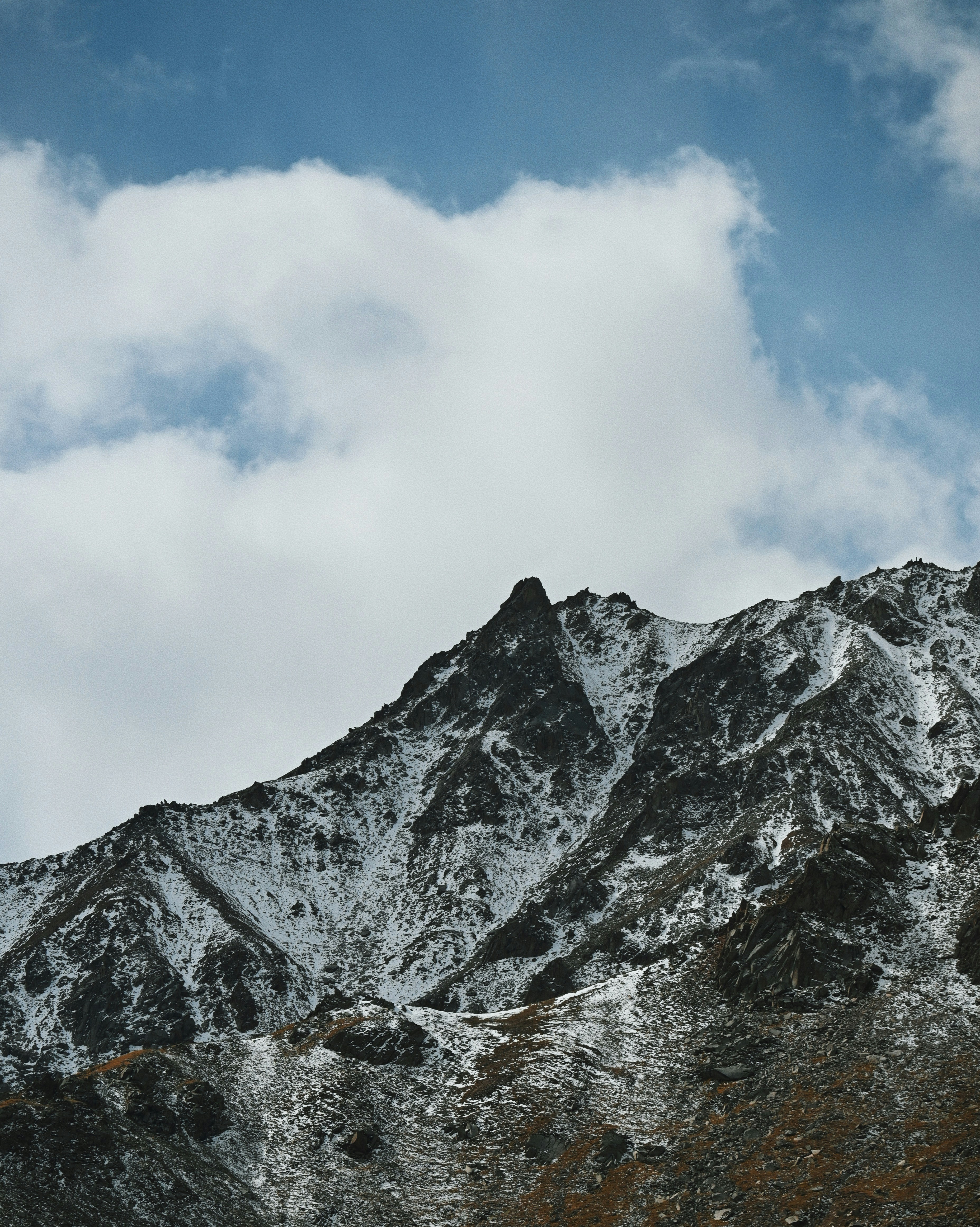 A snow covered mountain under a cloudy blue sky photo – Free Kazakhstan ...