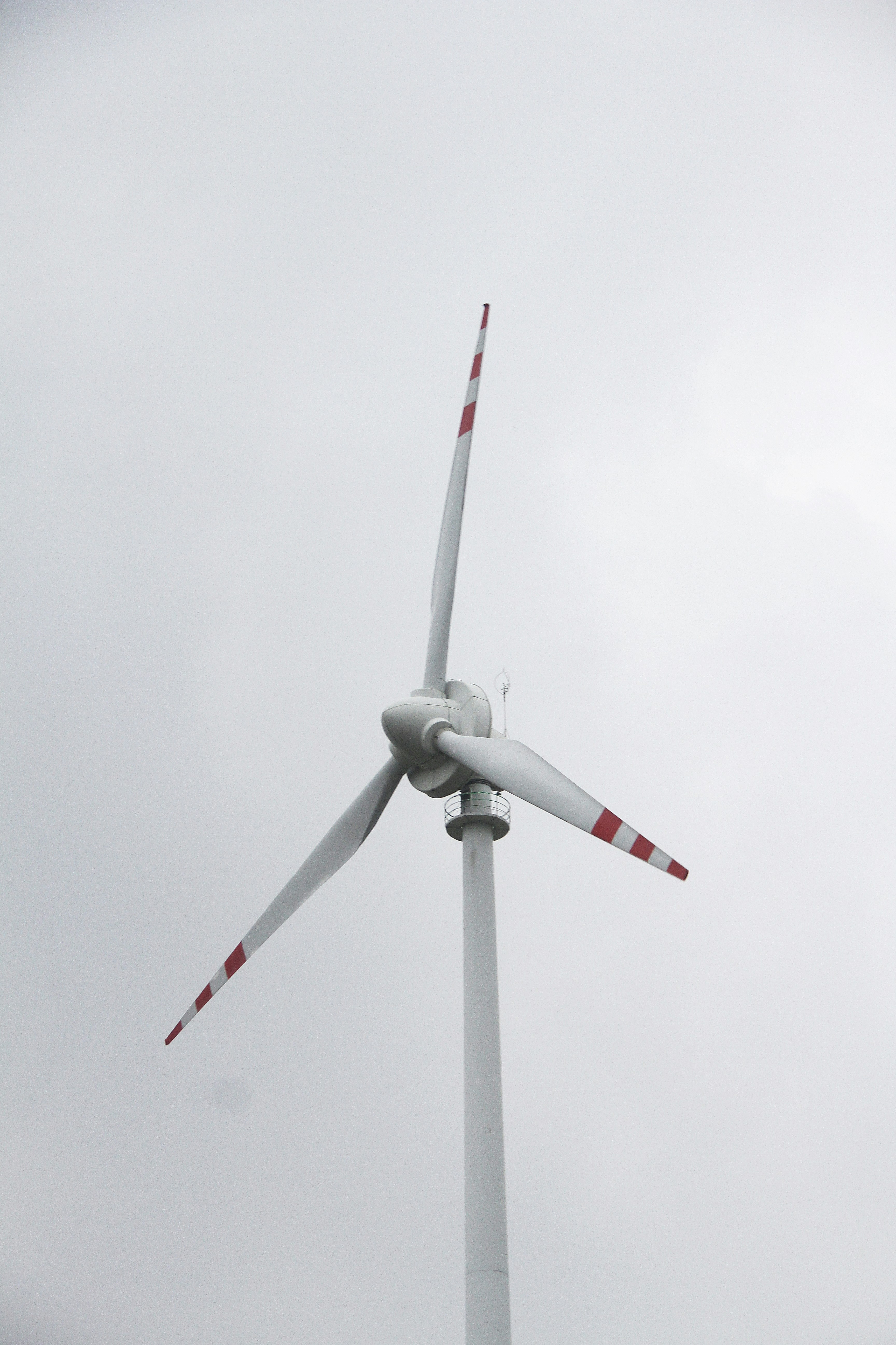 A towering wind turbine against a cloudy sky, showcasing its sleek blades and innovative design. The image highlights renewable energy technology in action.