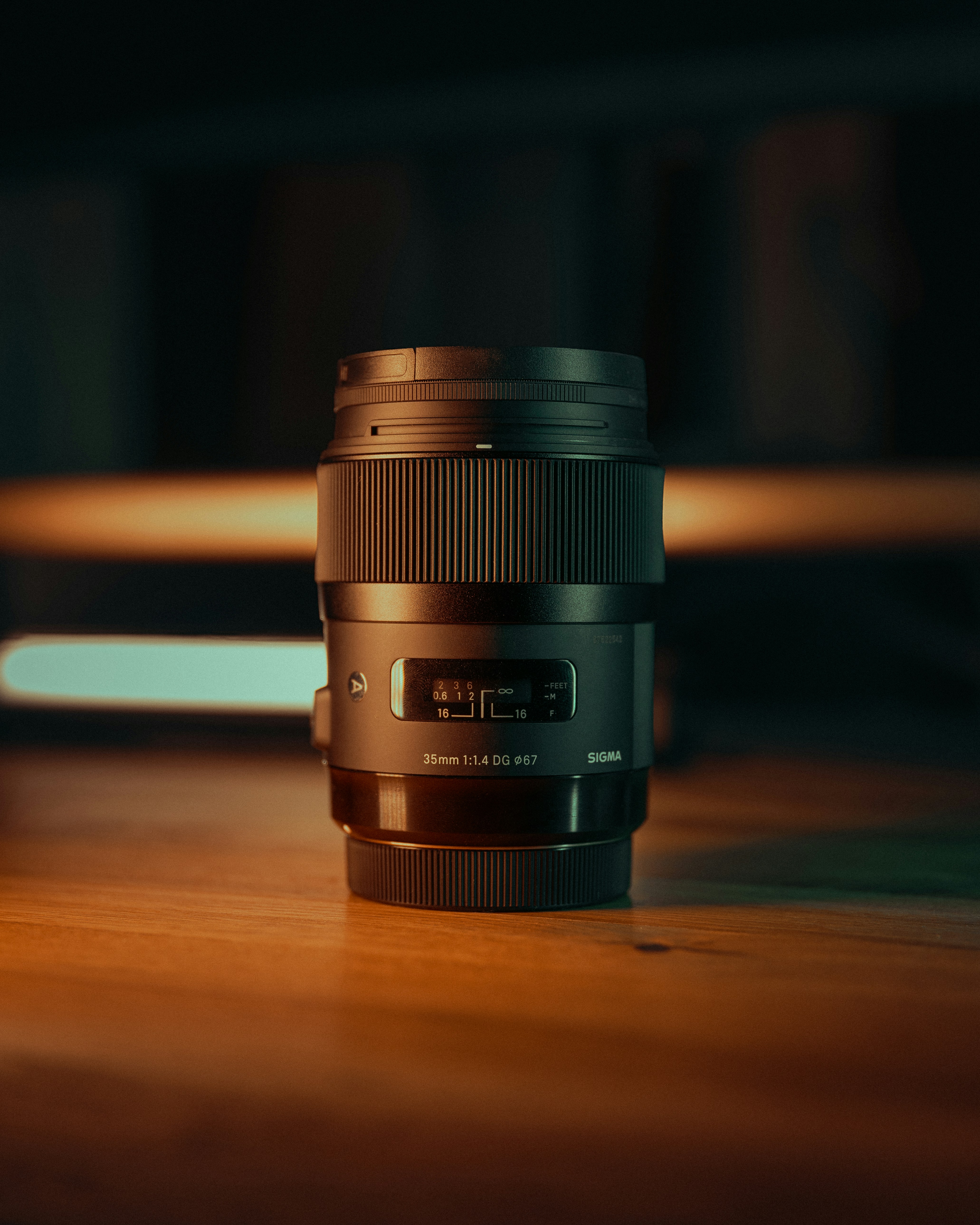 A camera lens sitting on top of a wooden table photo – Free Camera ...