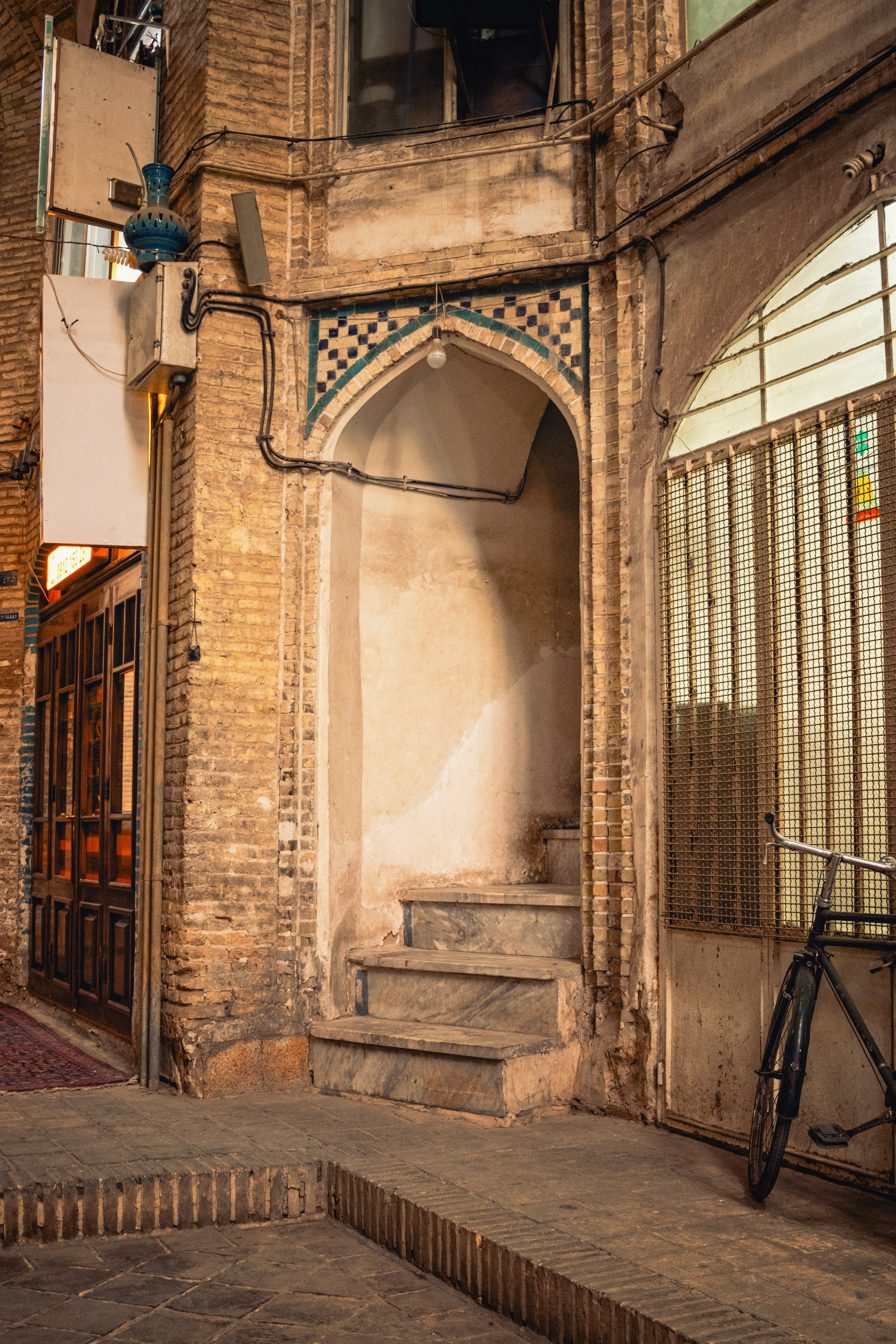 Arched passageway tucked between brick facades in a sunlit alley