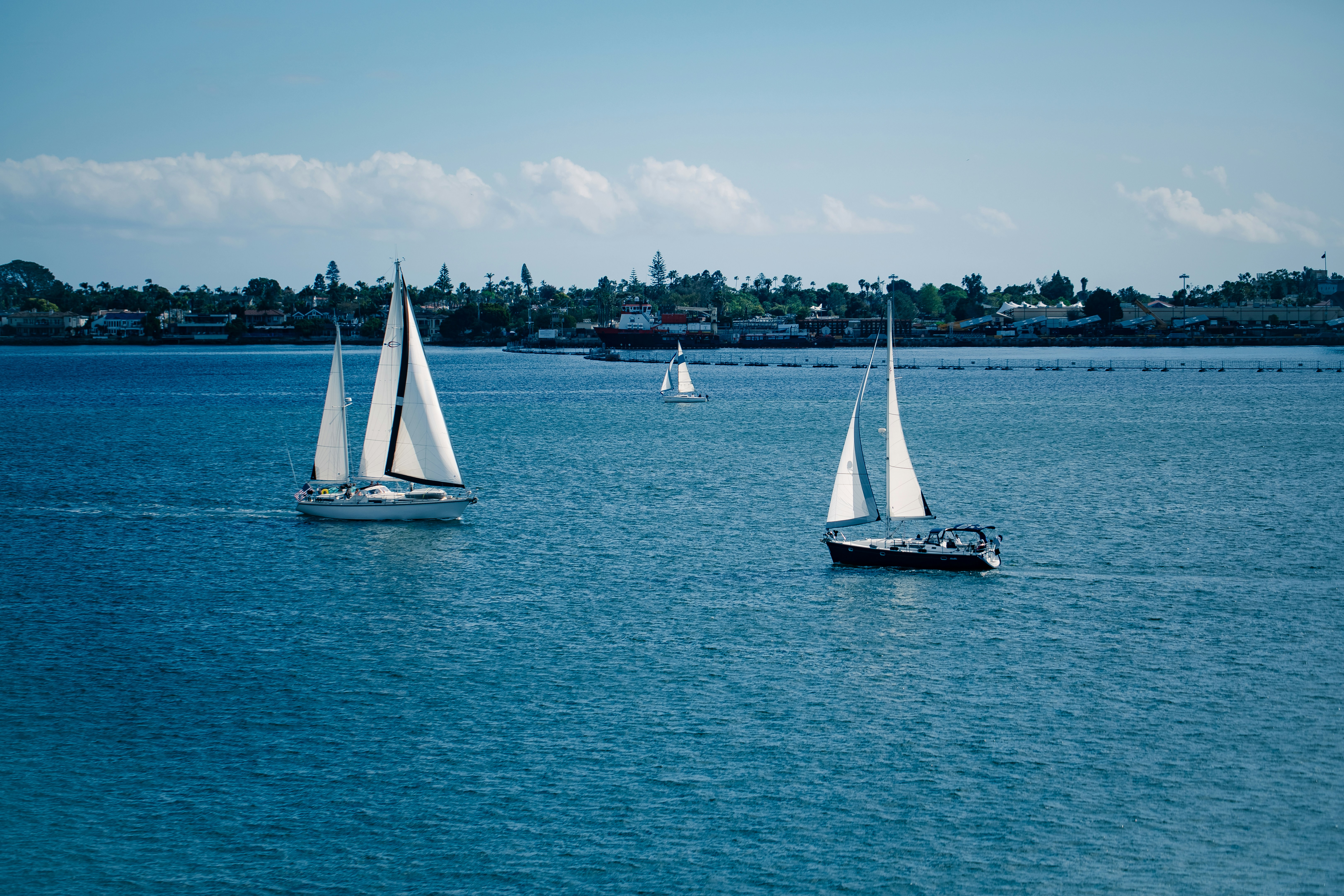 A couple of sail boats floating on top of a large body of water photo ...