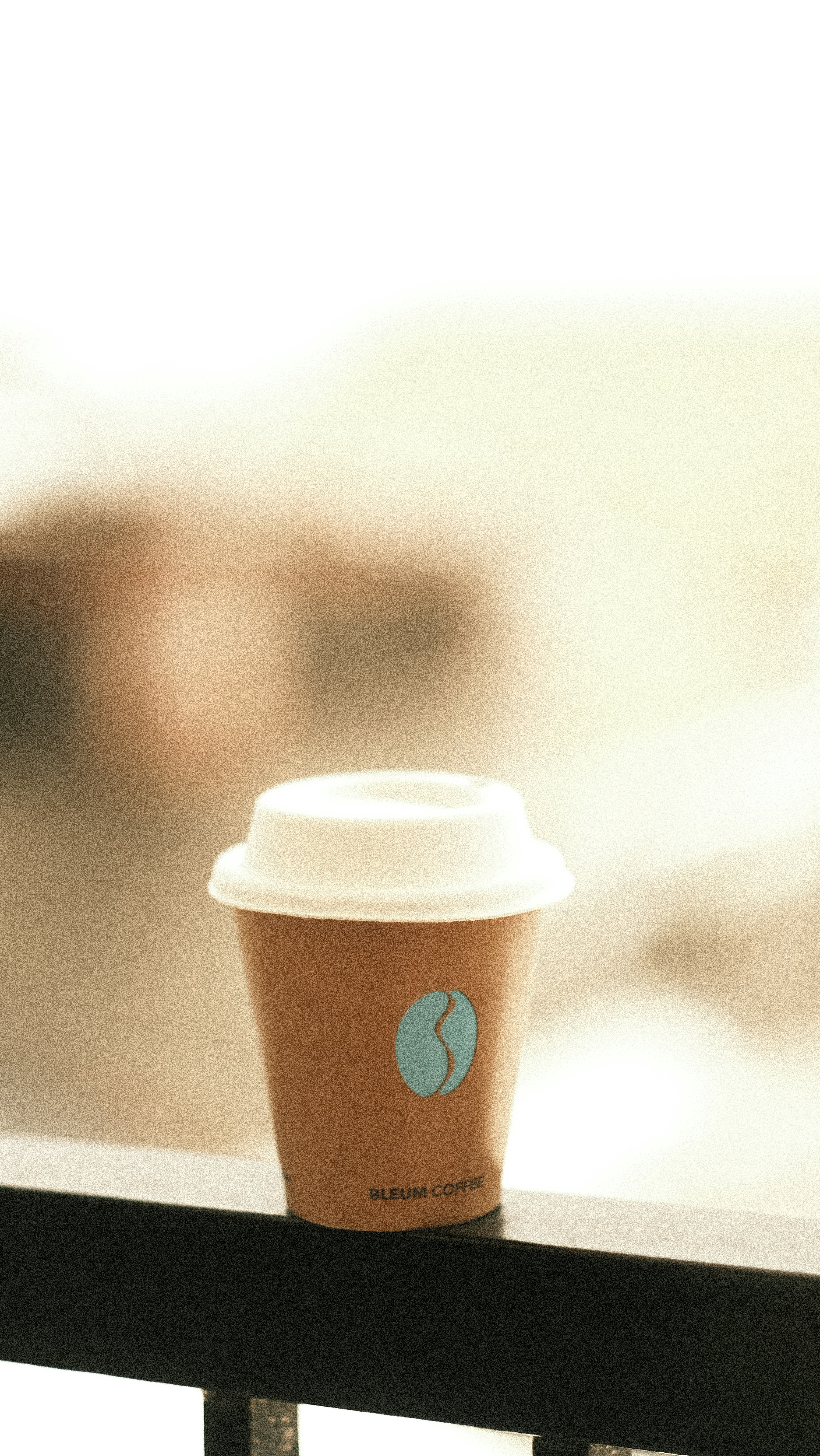 Sunlit Cup on a Rail: A Quiet Café Moment