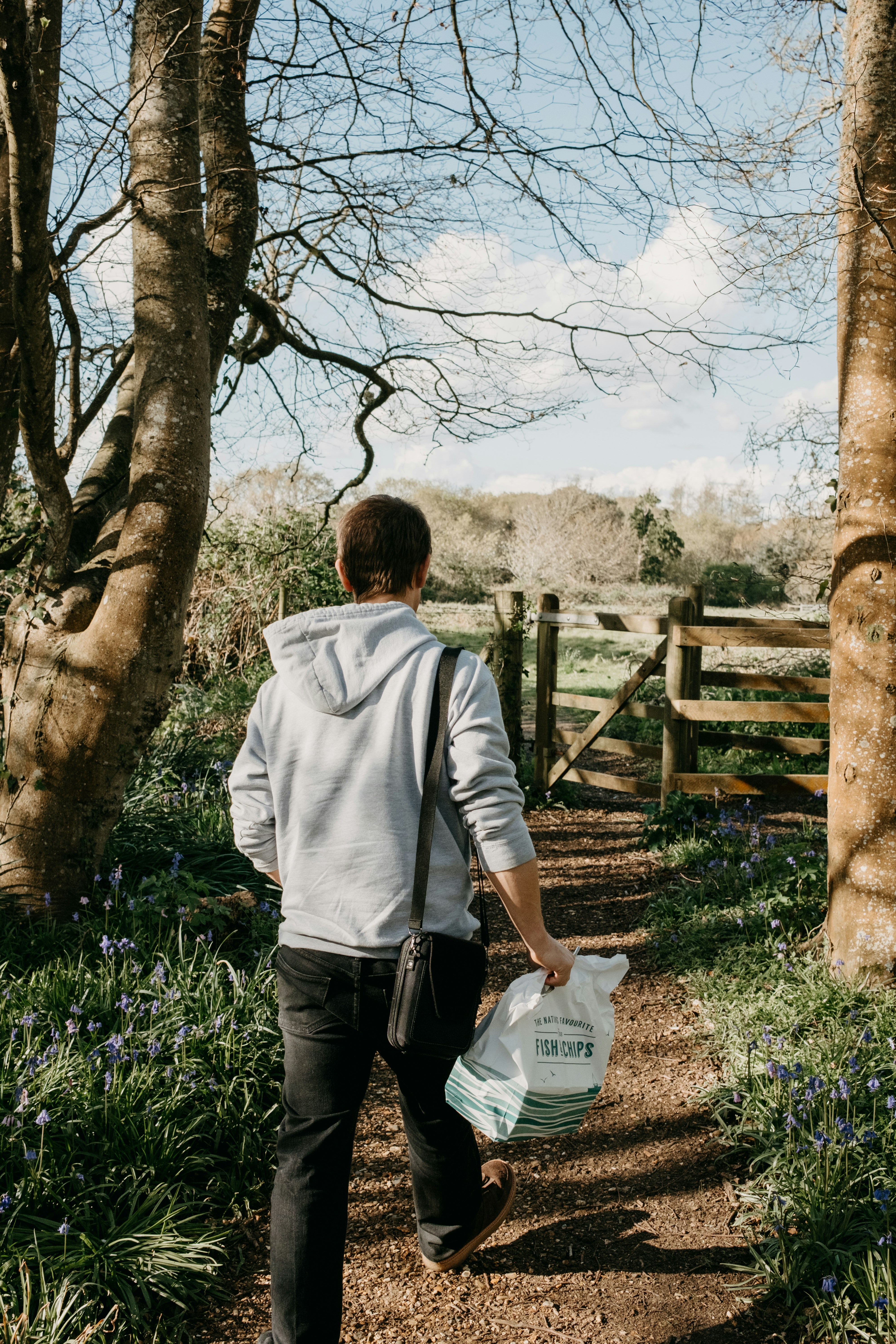 A man walking down a path carrying a bag photo – Free Grey Image on ...