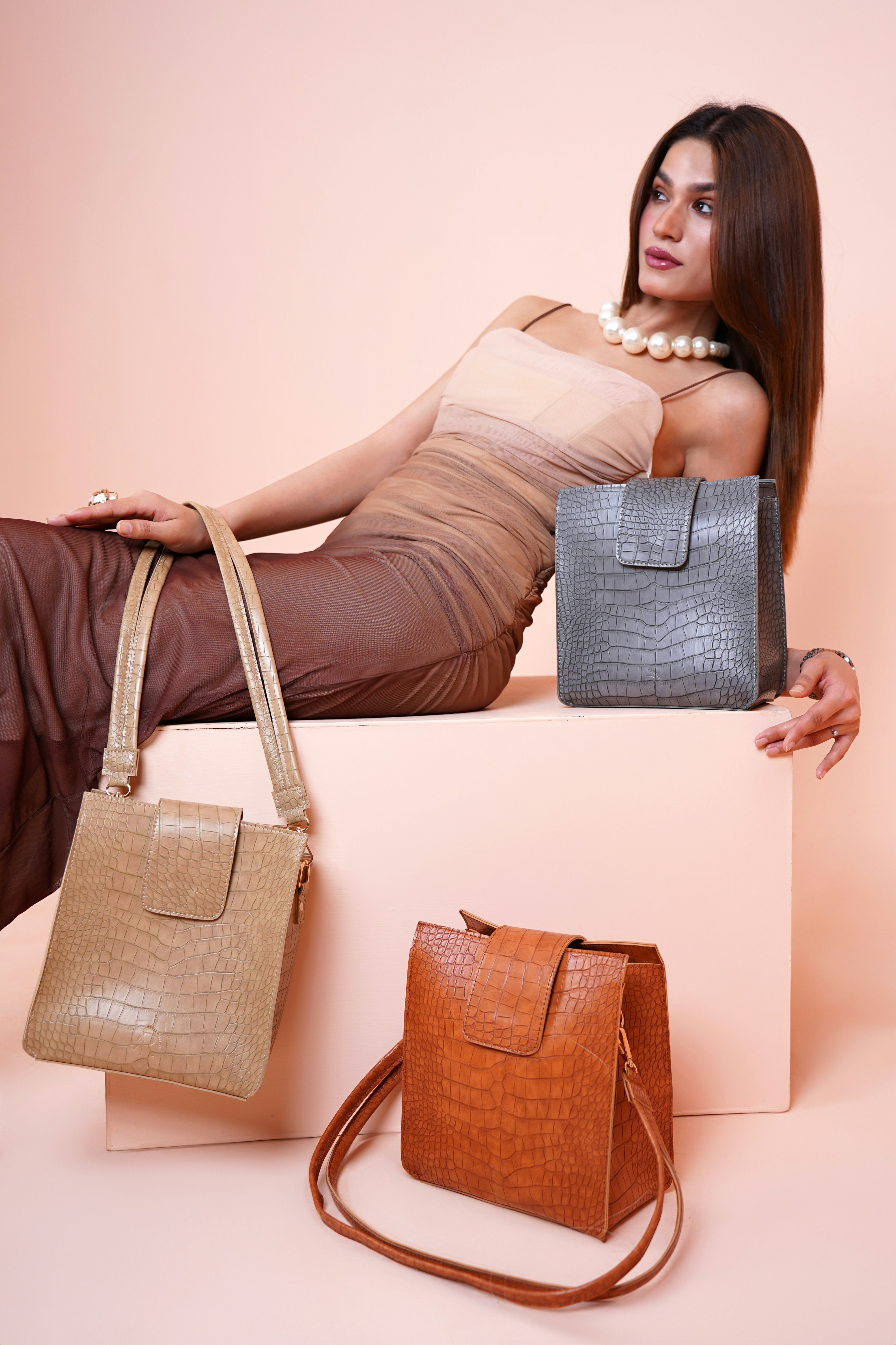 A woman sitting on a box holding two purses photo – Free Lahore Image ...