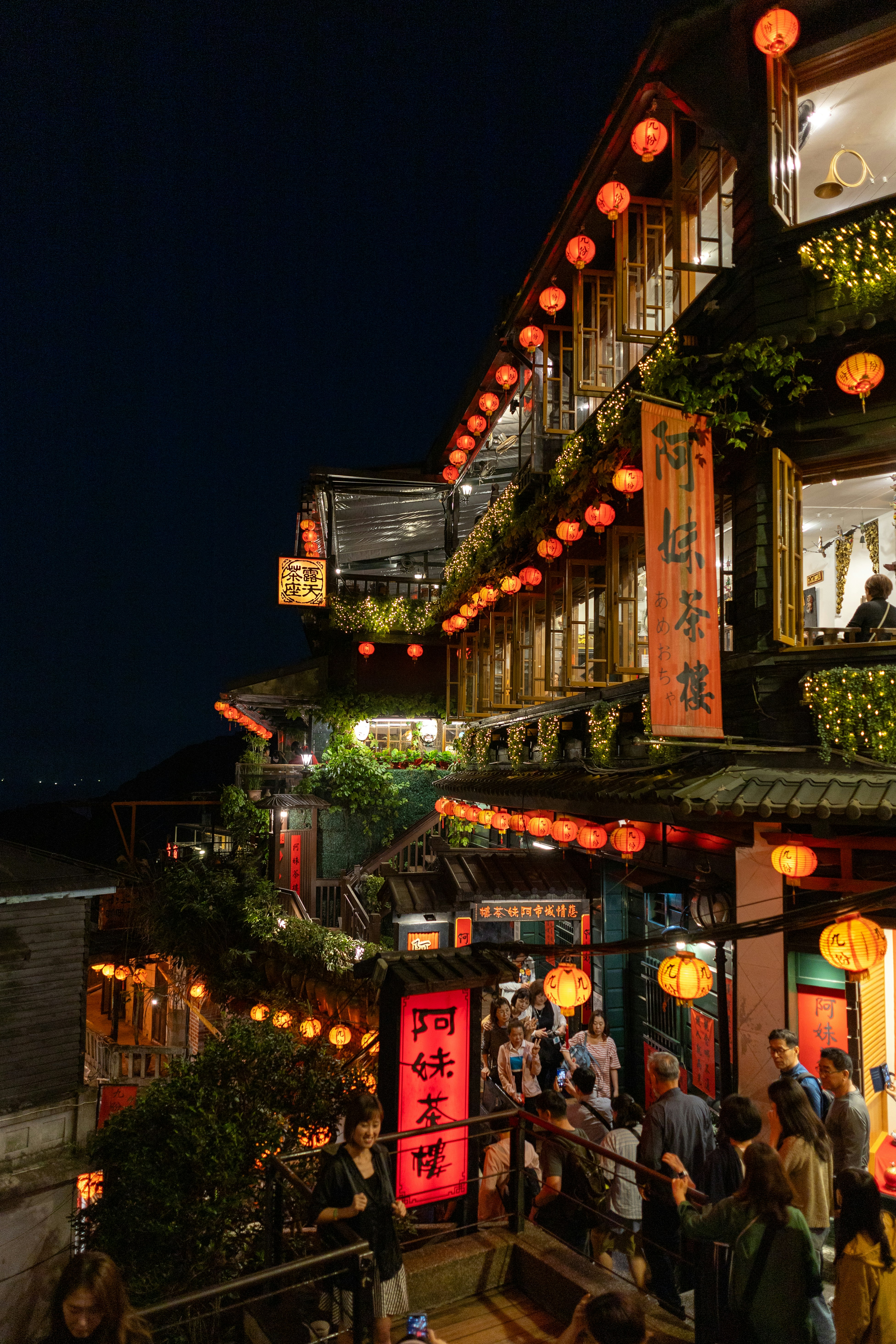 a group of people standing outside of a building at night