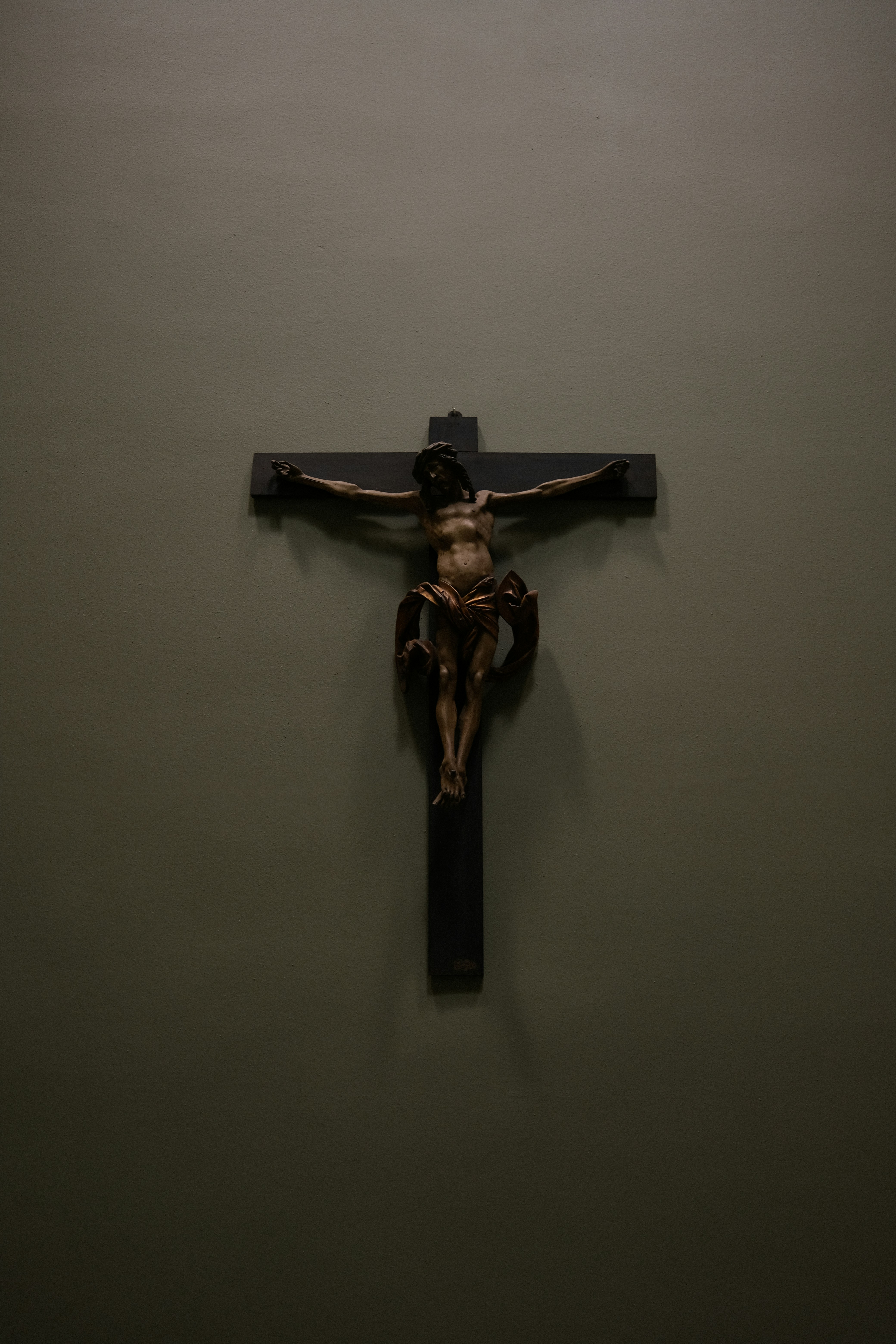 A crucifix hanging on a wall in a room photo – Free Man Image on Unsplash
