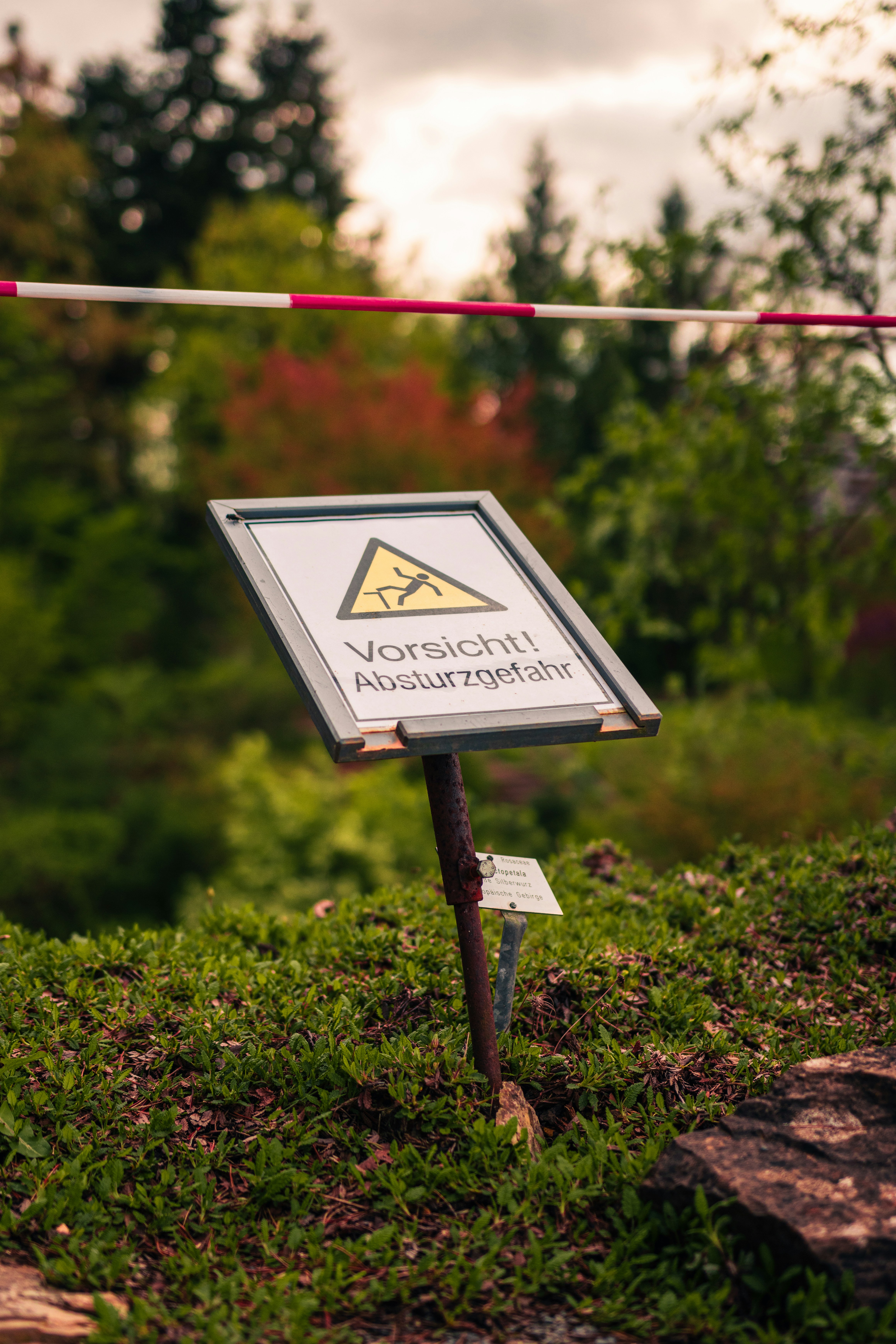 Tilted Warning Sign Over a Quiet Park Verge