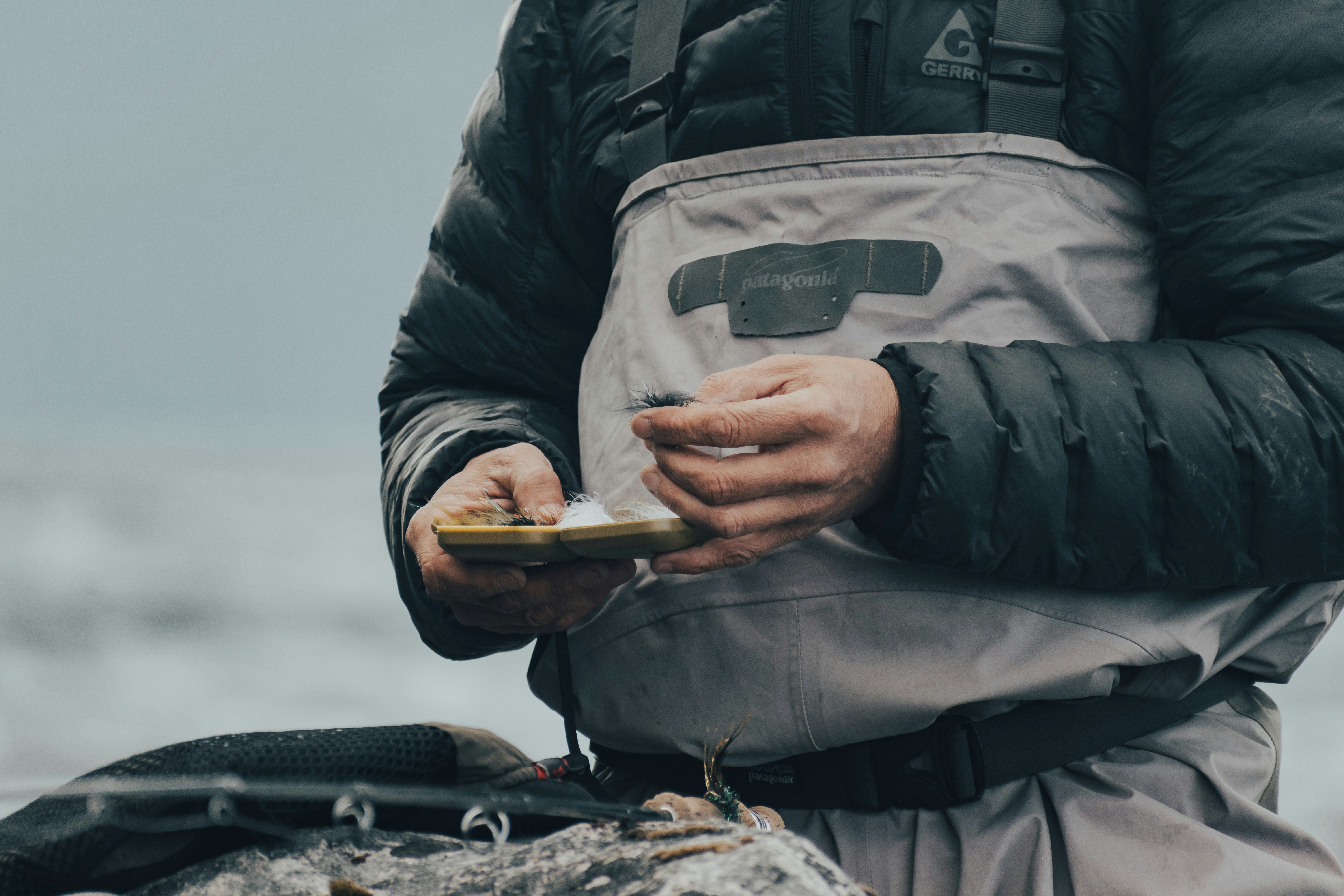 Gloved Hands at a River Edge: Phone Check in the Cold