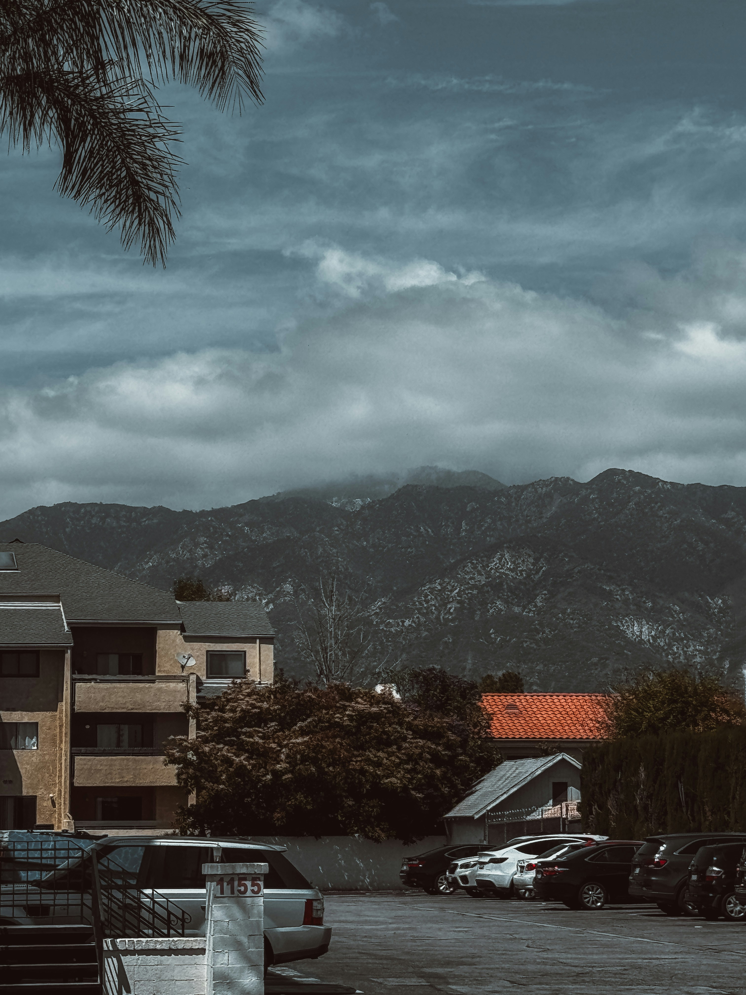 Fringe Horizon: Quiet Parking Lot Beneath a Blue-Gray Mountain Ridge