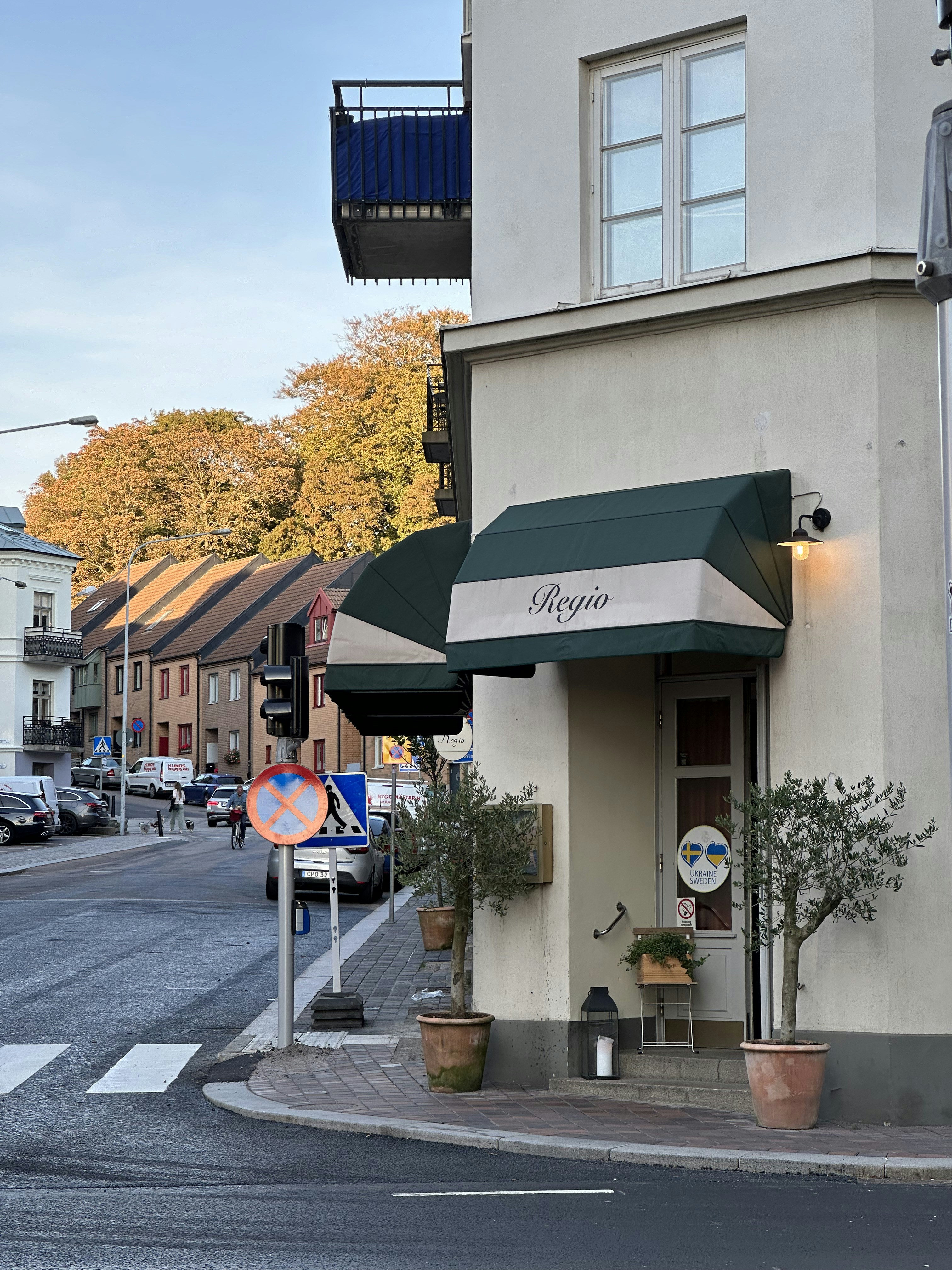 Corner Café with Green Awnings on a Quiet Autumn Street