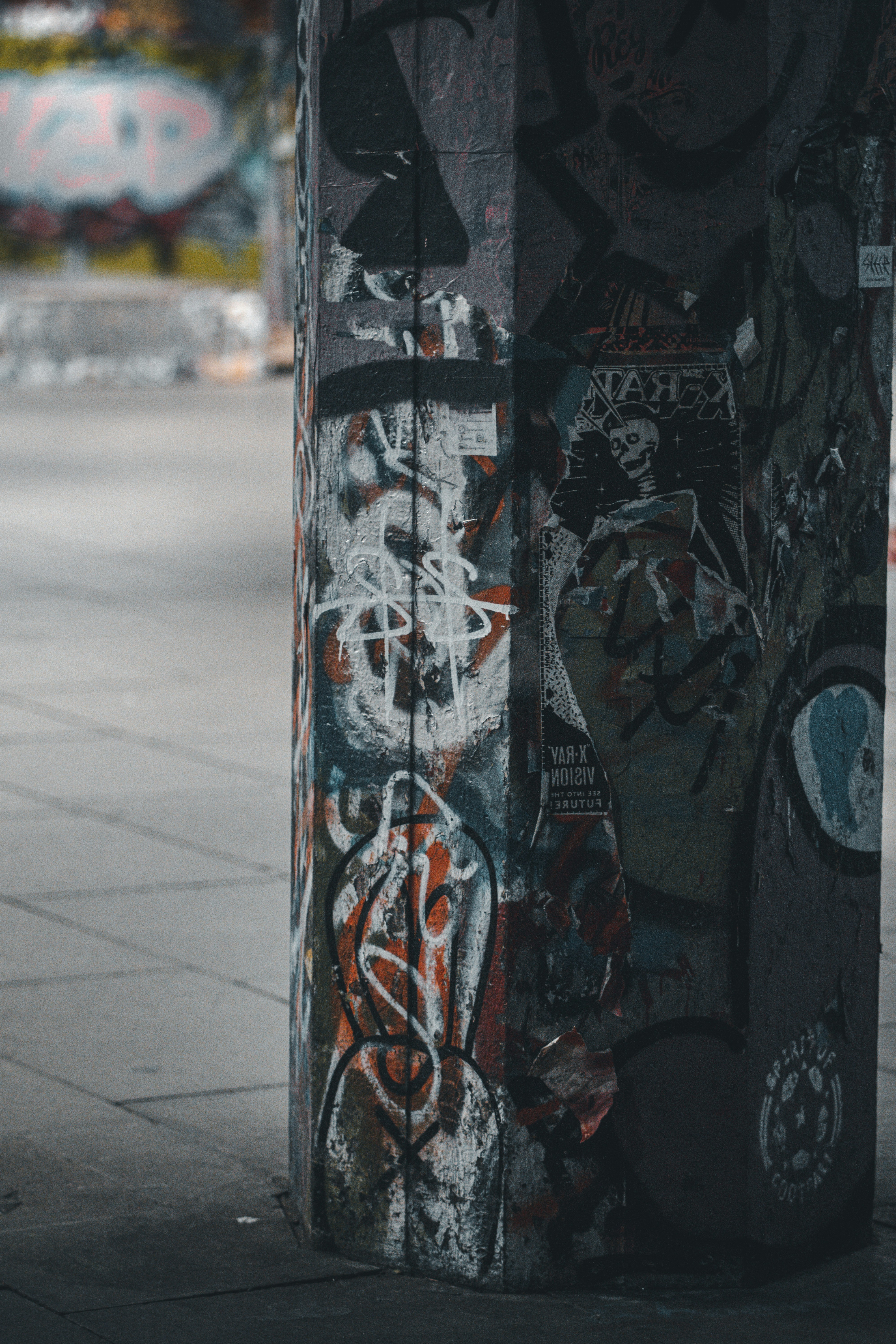 A pole covered in graffiti on the side of a road photo – Free Grey ...