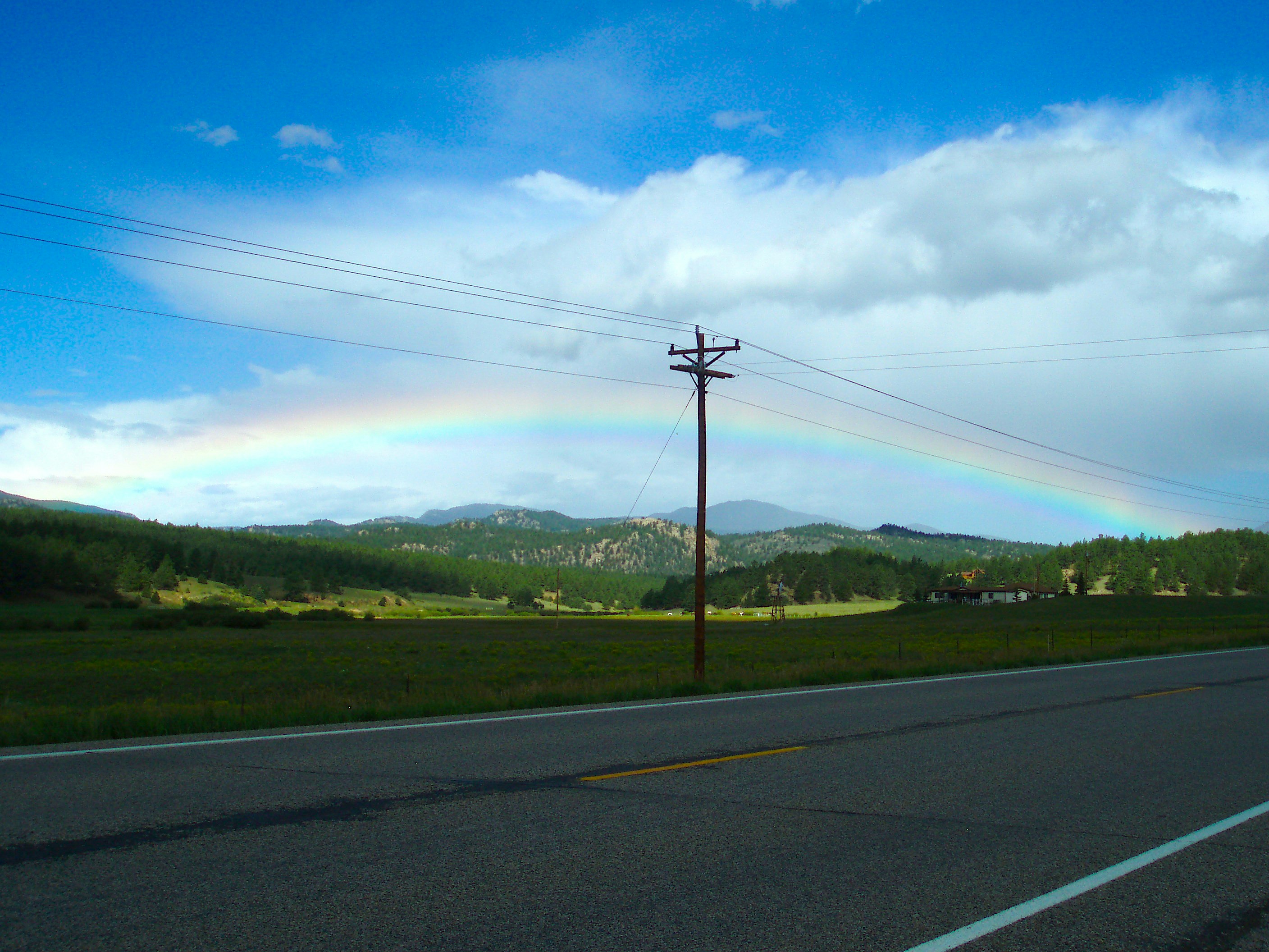 A rainbow in the sky over a road photo – Free Tarryall mountains lost ...