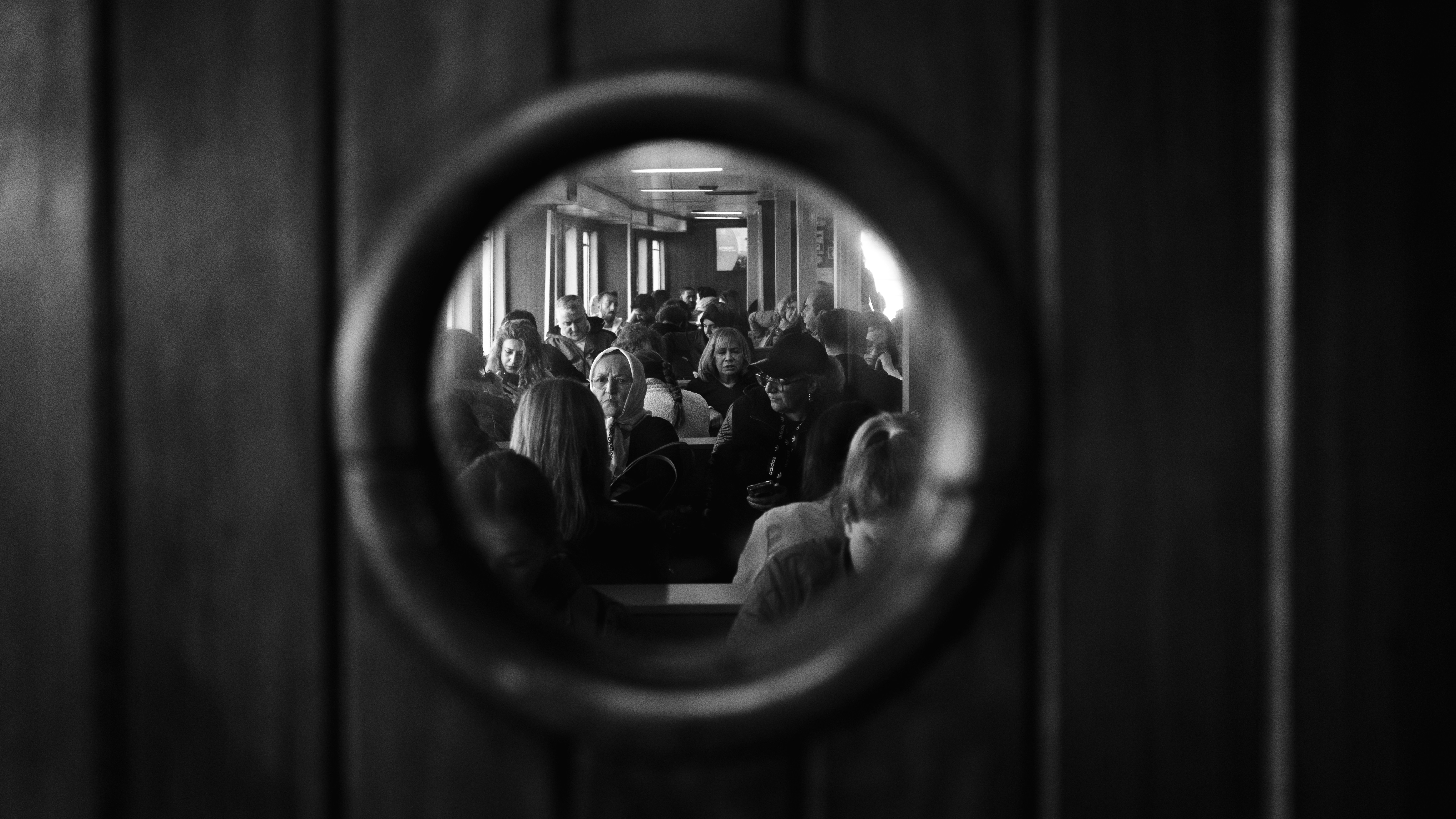 Through the Circular Window: Commuters in Quiet Focus