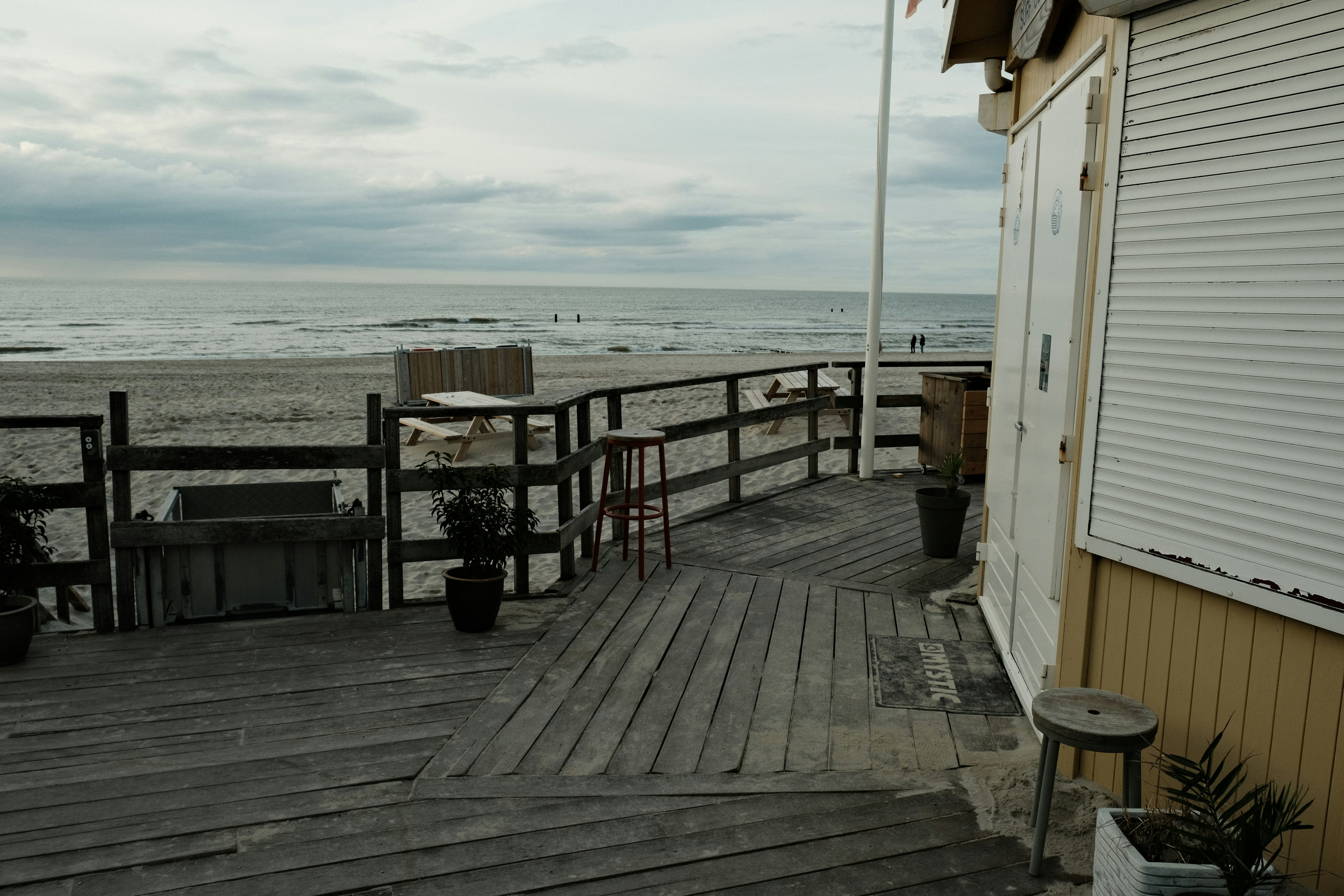 A wooden deck next to a building on a beach photo – Free Beach Image on ...