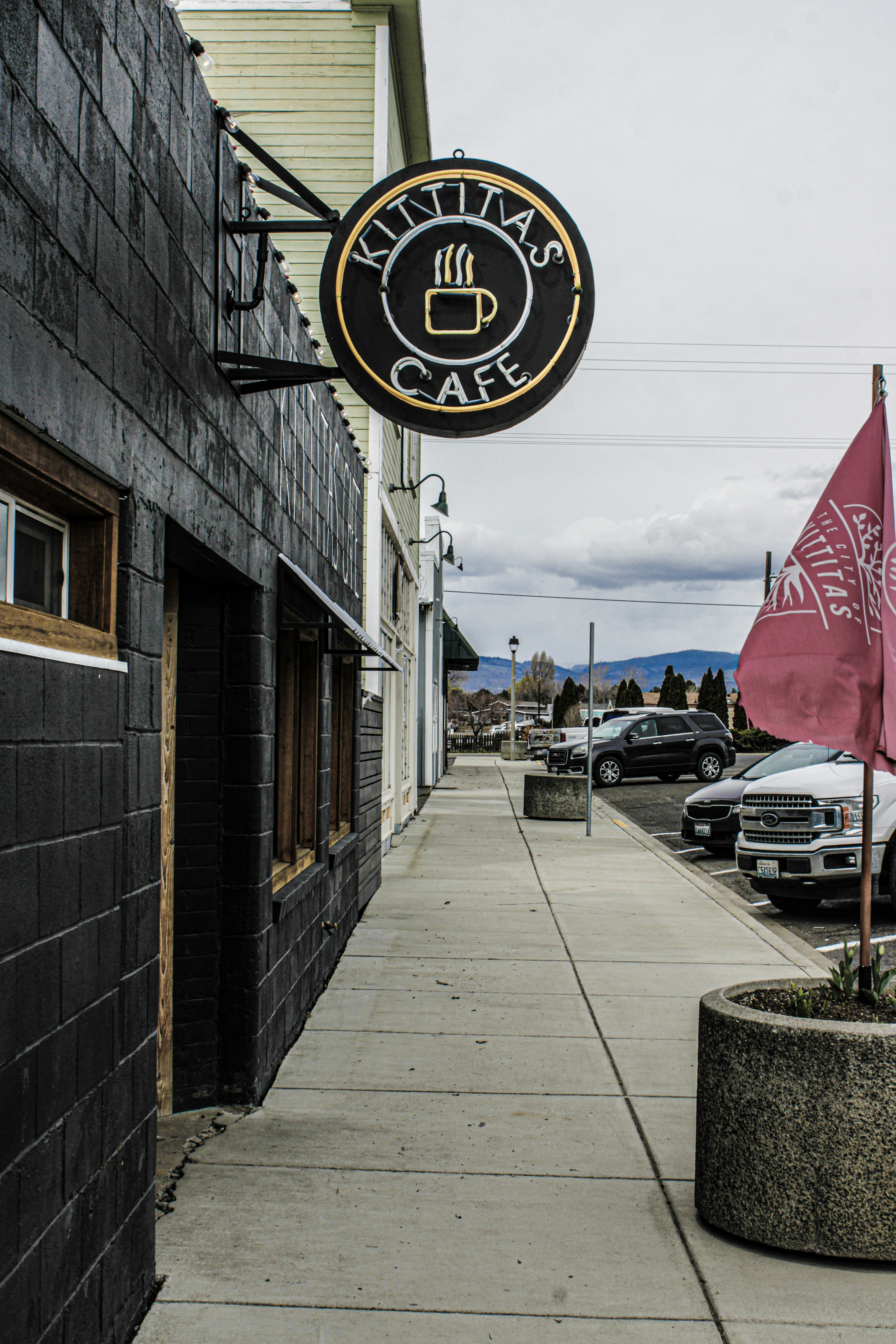 Circular Morning Beacon: A Café Sign Anchors the Street