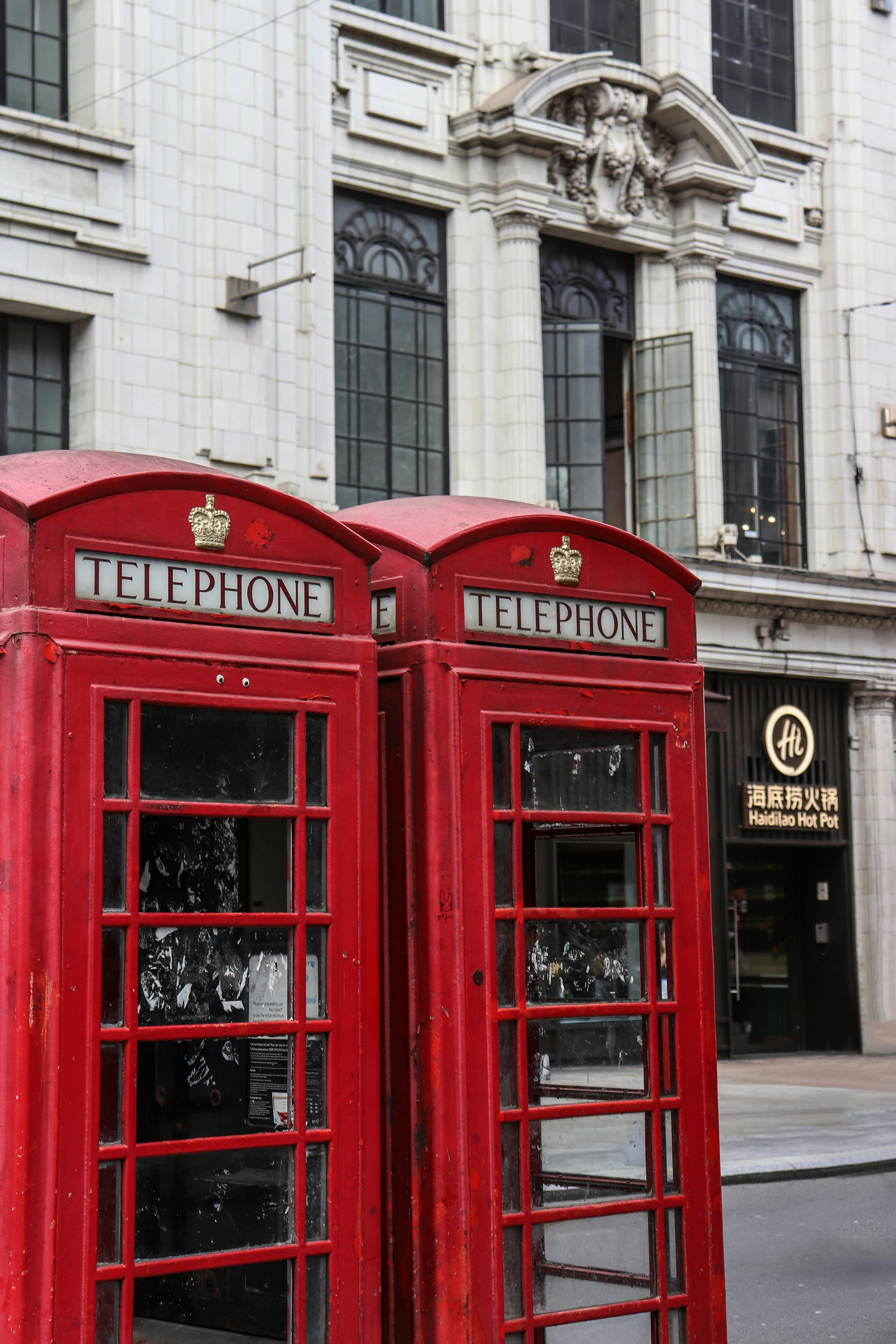 Two red telephone booths in front of a building photo – Free London ...