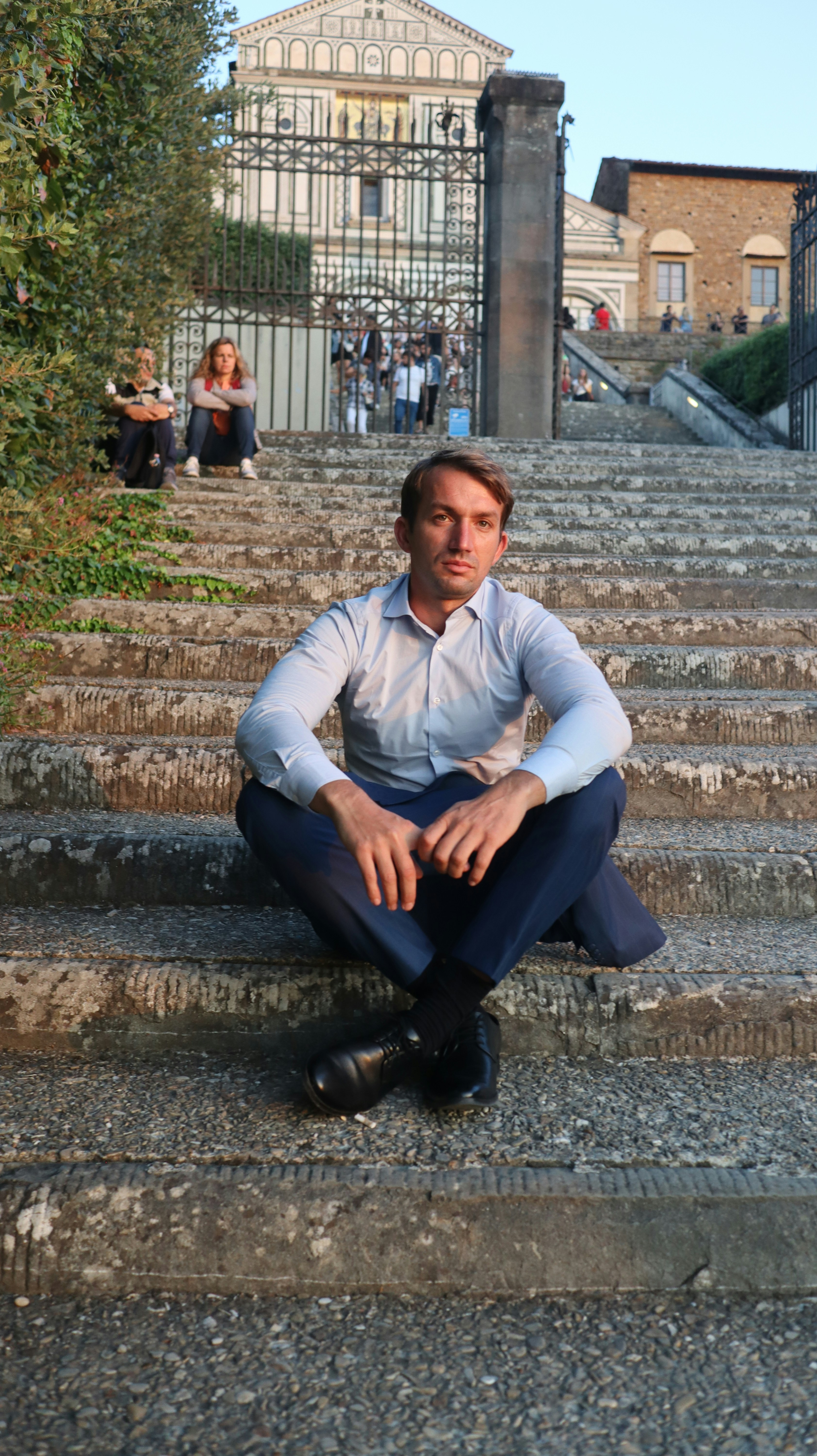 A man sitting on the steps of a building photo – Free Italy Image on ...