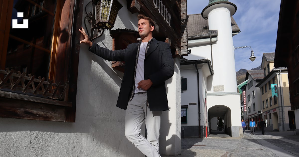 Un Hombre De Traje Apoyado En Un Edificio Foto Imagen De Suiza