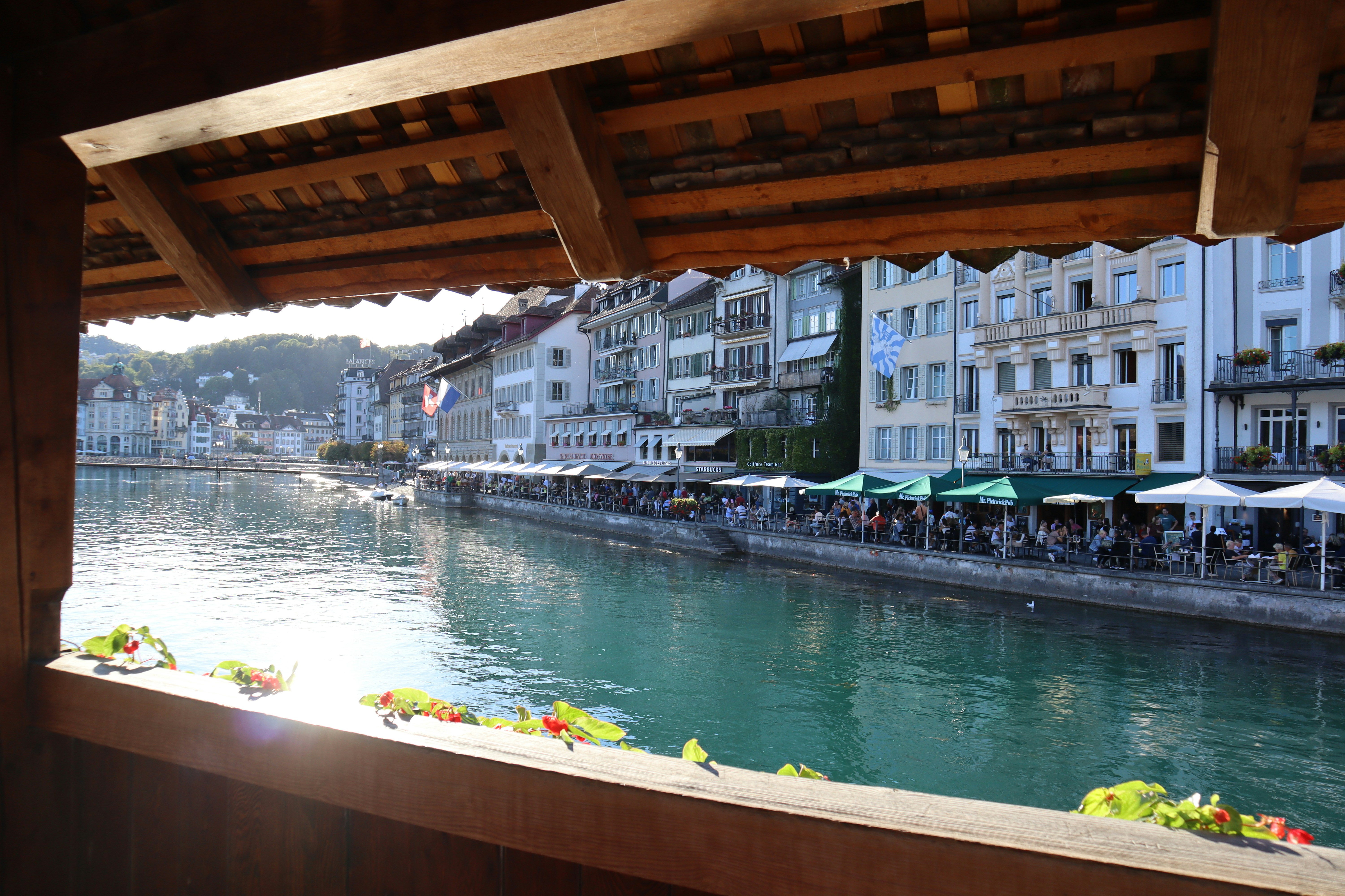 View from a sheltered balcony over a sunlit canal lined with historic buildings