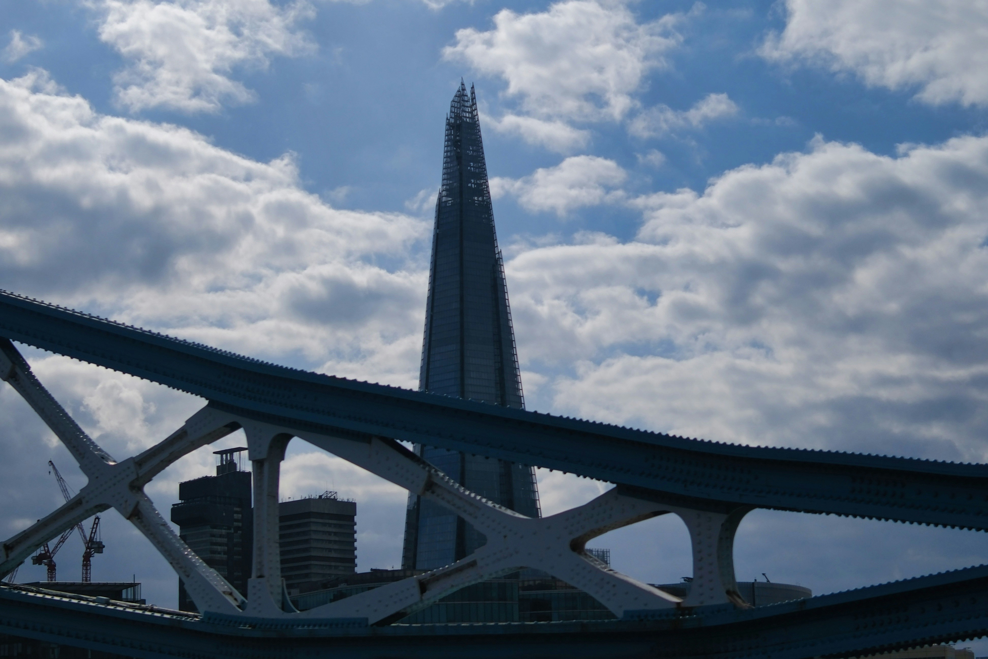 A very tall building towering over a city under a cloudy sky photo ...