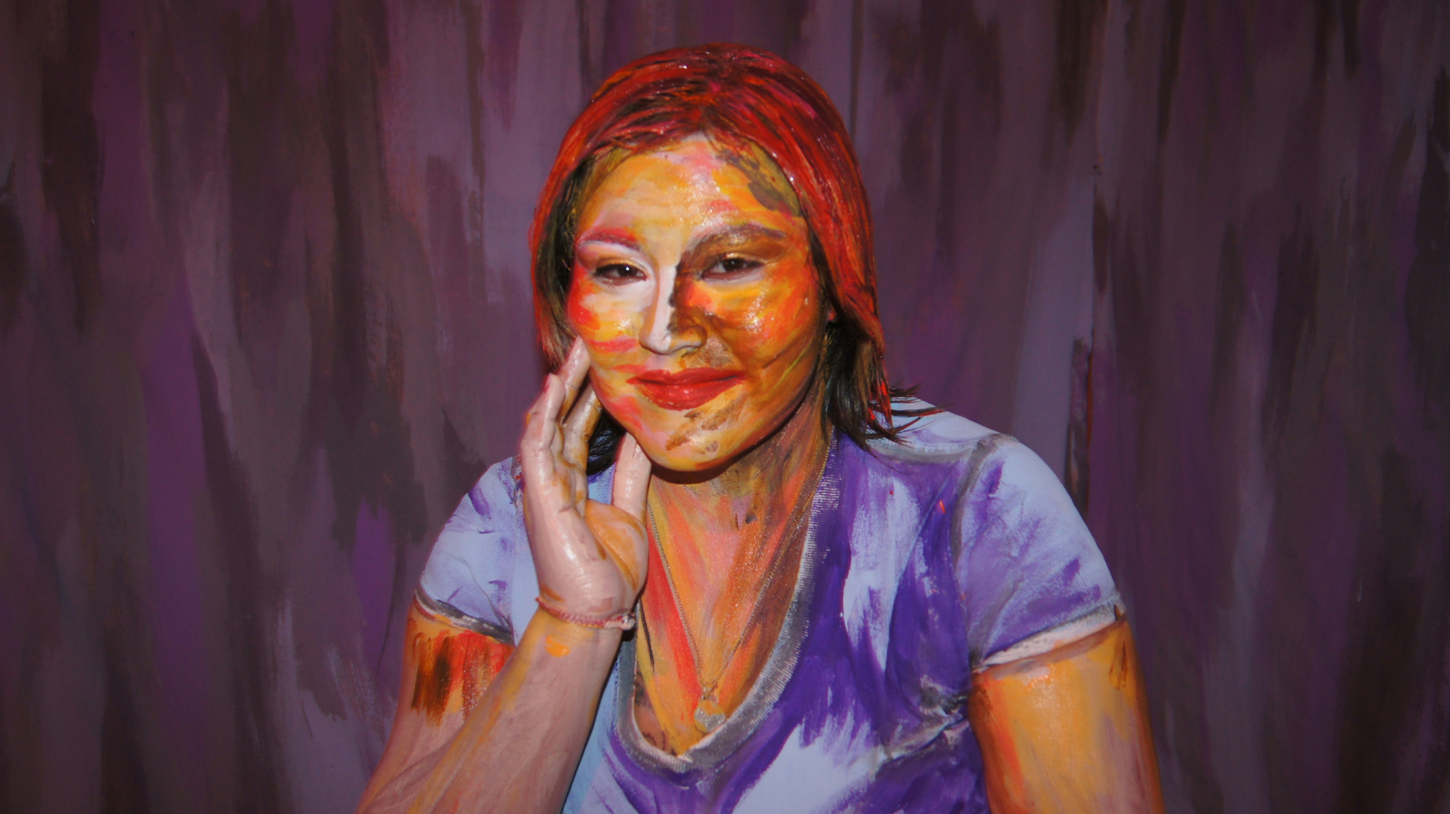 Expressionist painting of a woman with fiery makeup against a purple backdrop. Visible brushwork adds texture and mood.