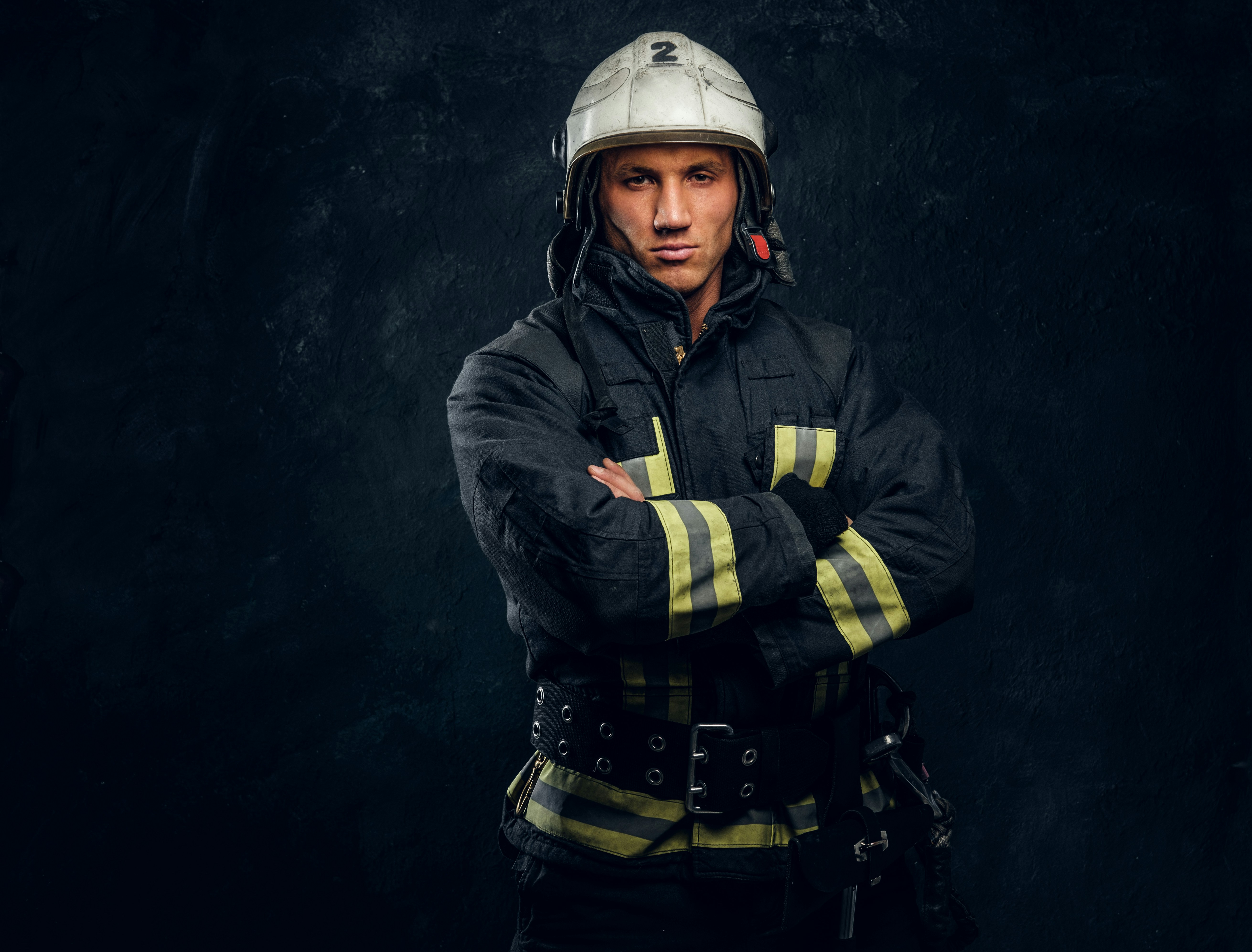 A man in a fireman's uniform with his arms crossed photo – Free Suit ...