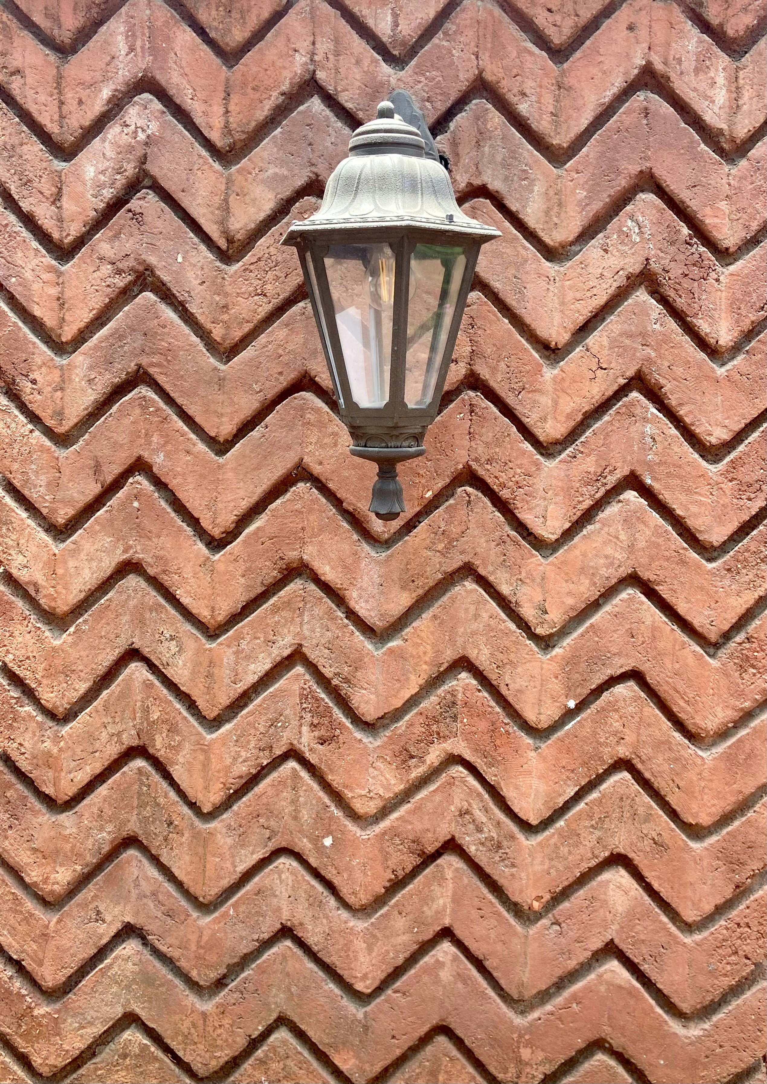 Weathered Lantern Framed by a Chevron Brick Mosaic