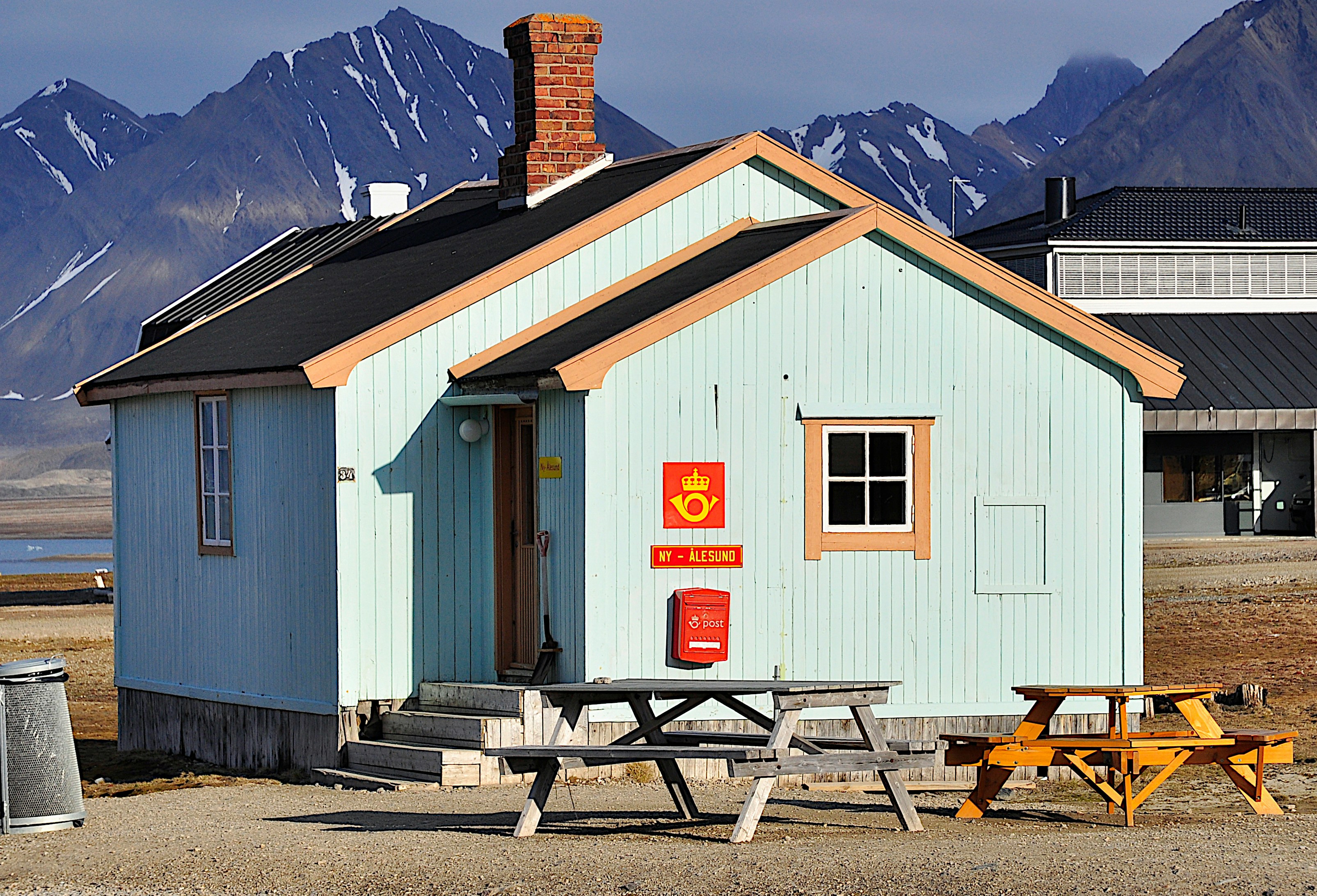 A small blue building with a picnic table in front of it photo – Free ...