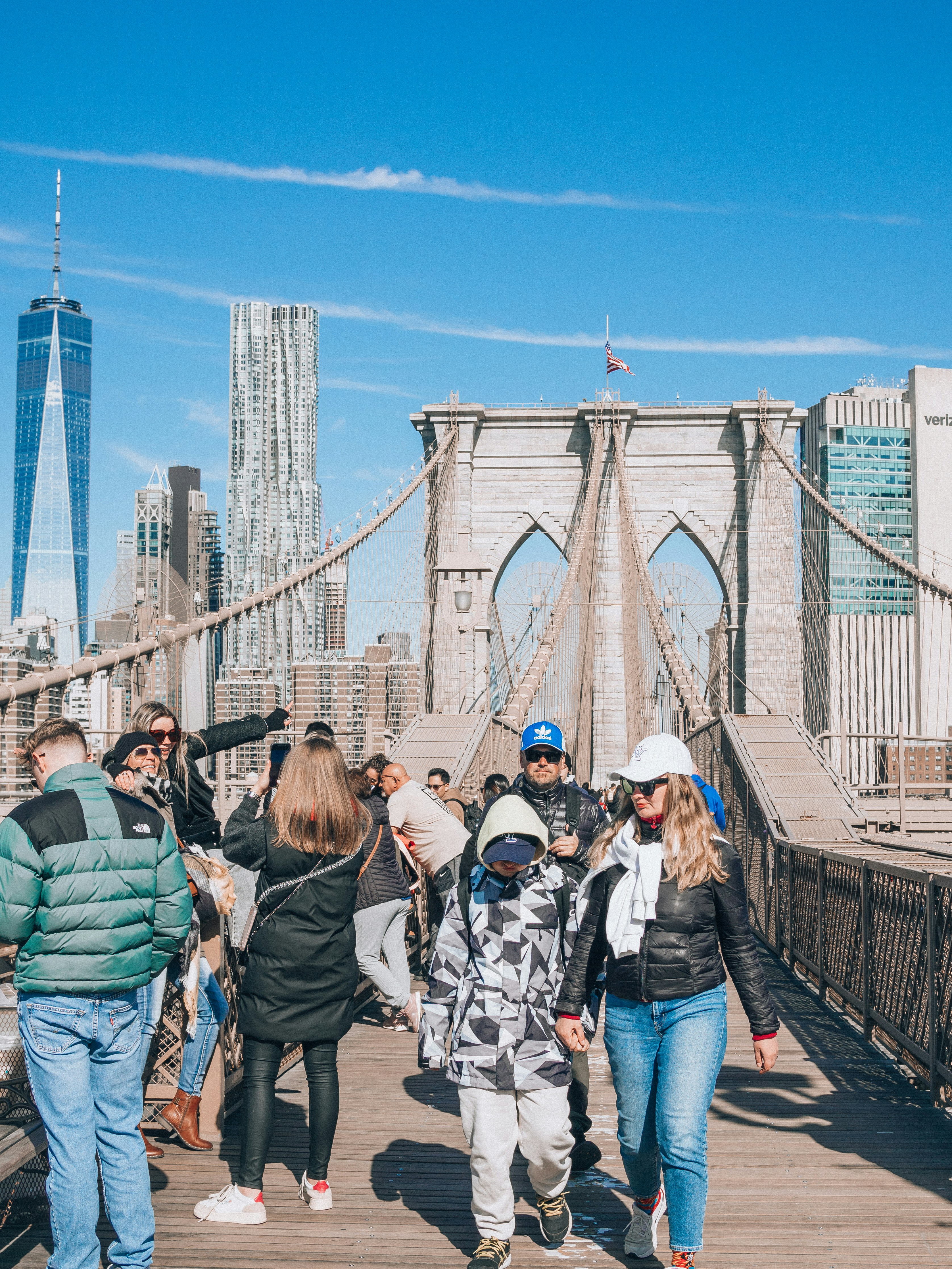 A group of people walking across a bridge photo – Free Woman Image on ...