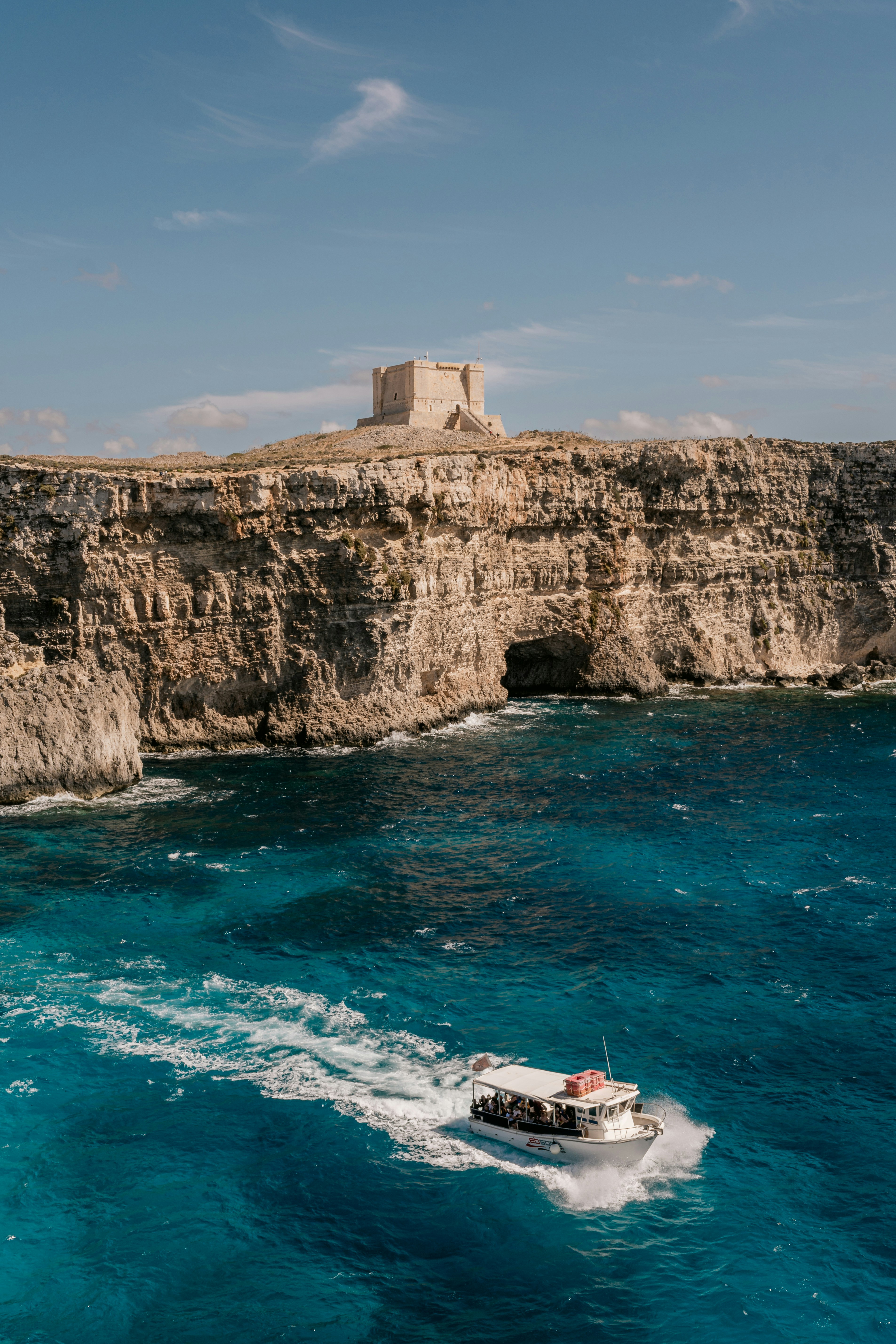 A small boat in the water near a cliff photo – Free Comino Image on ...