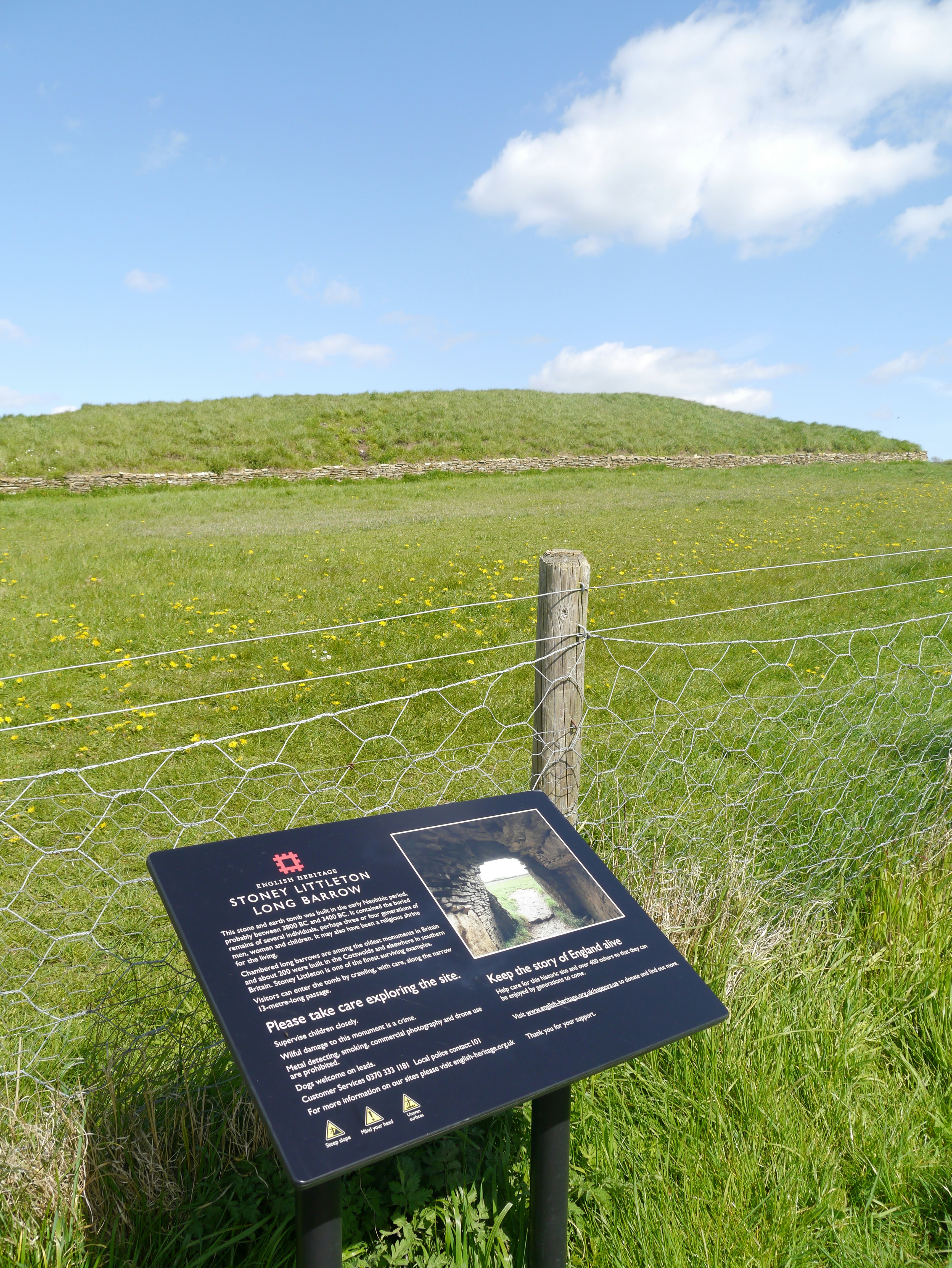 a sign in front of a fence in a field