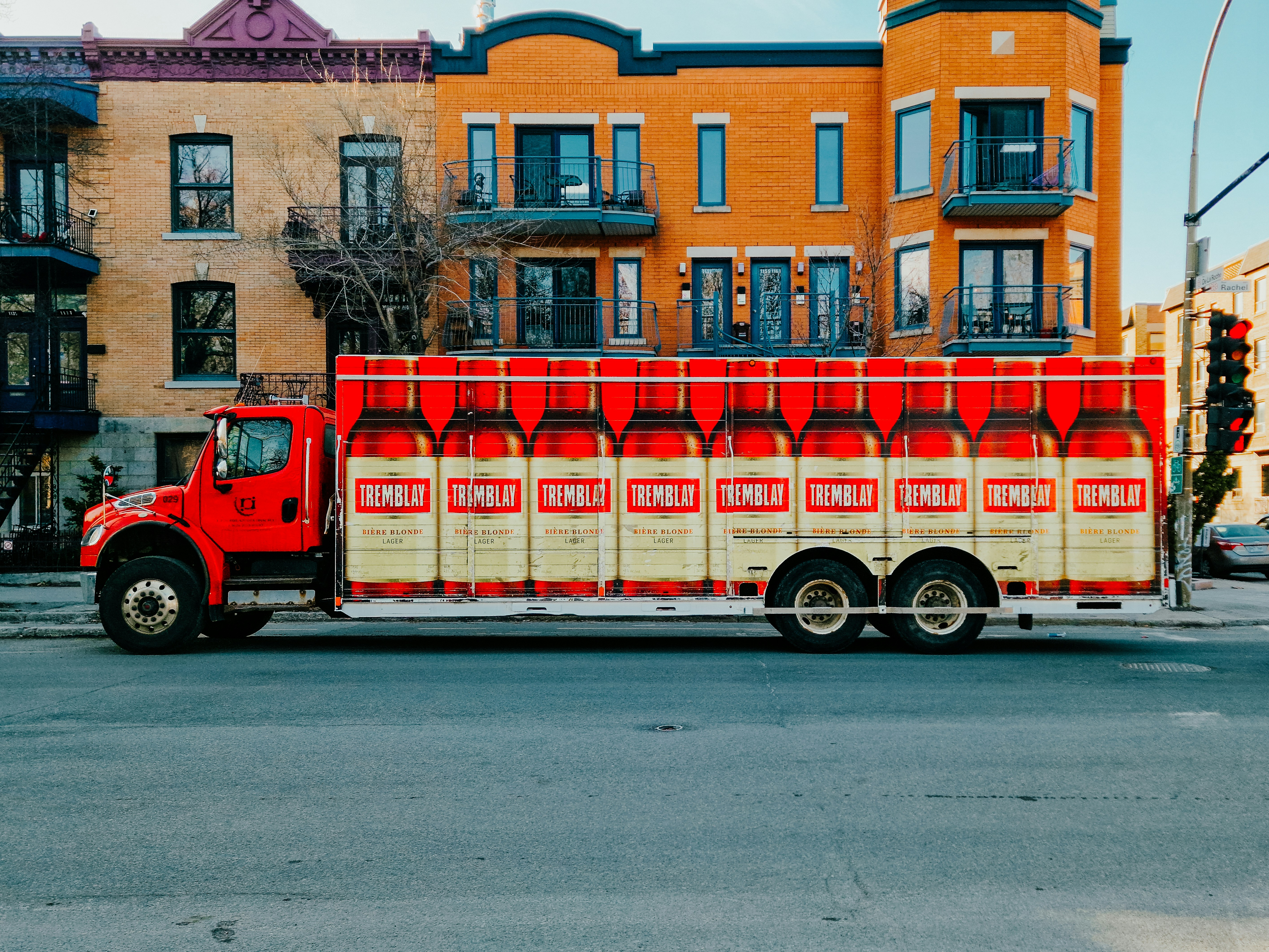 Crimson Cargo Rides Through a Colorful Urban Block