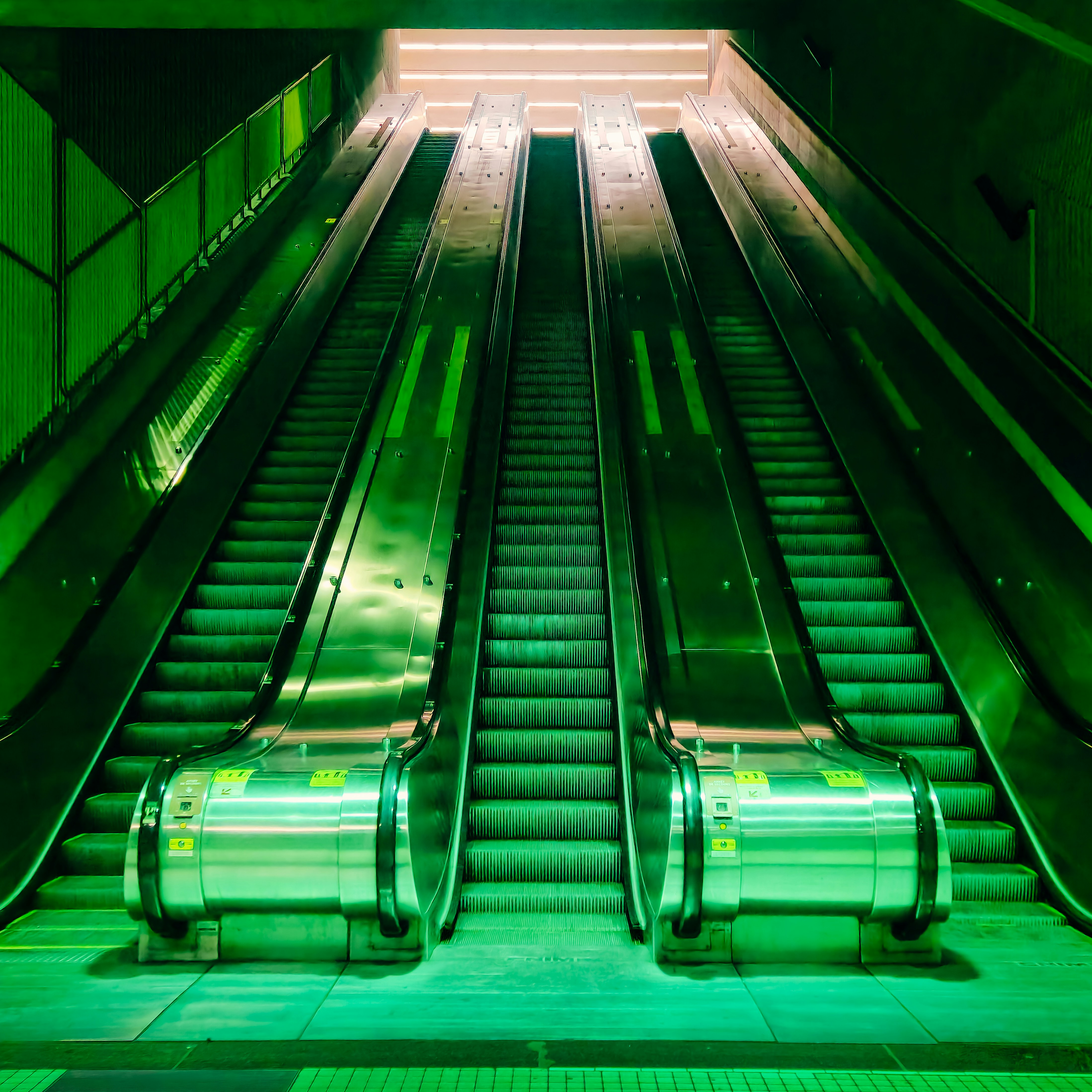 Emerald Descent: Twin Escalators Bathed in Neon Green