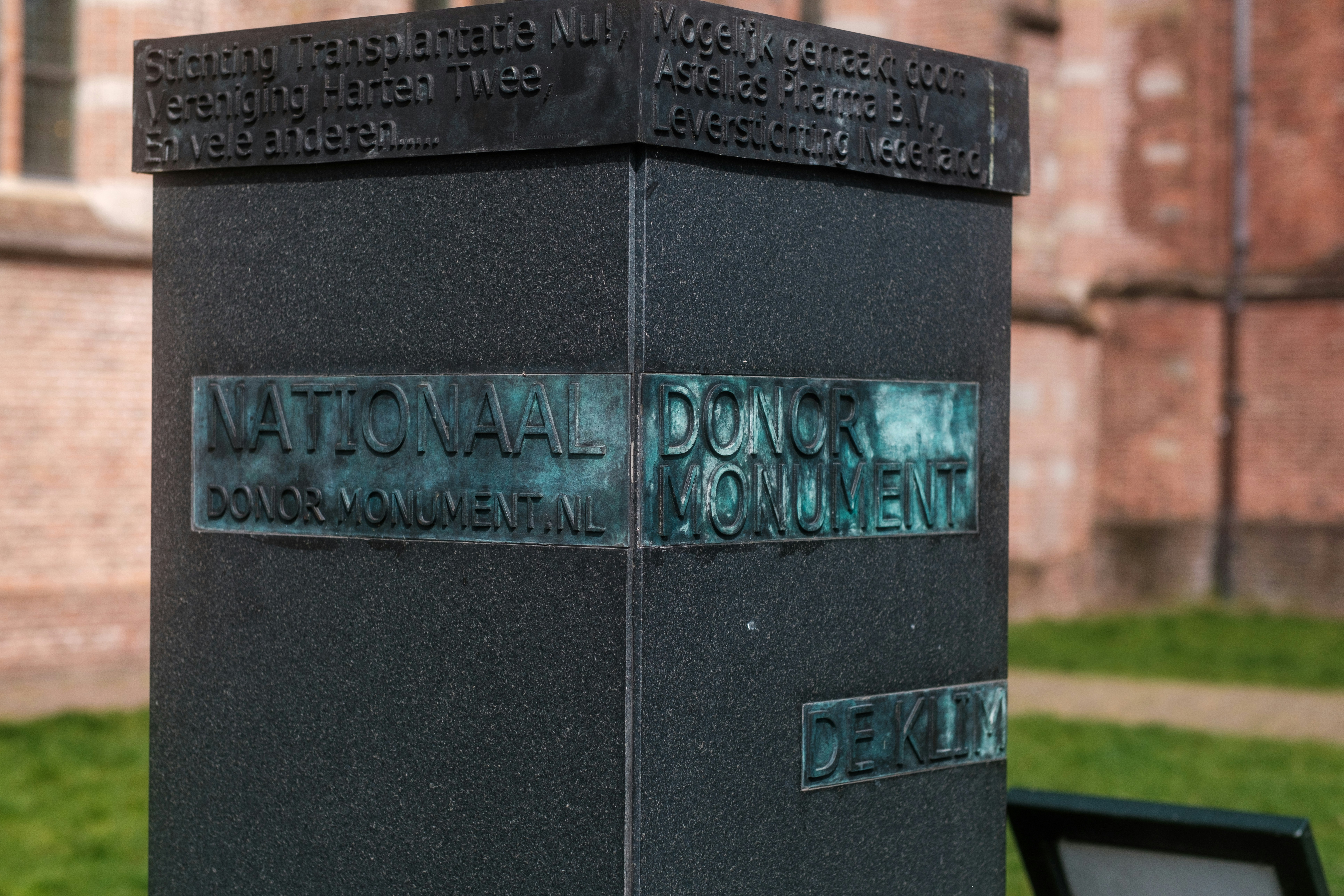 A monument in front of a brick building photo – Free Grey Image on Unsplash