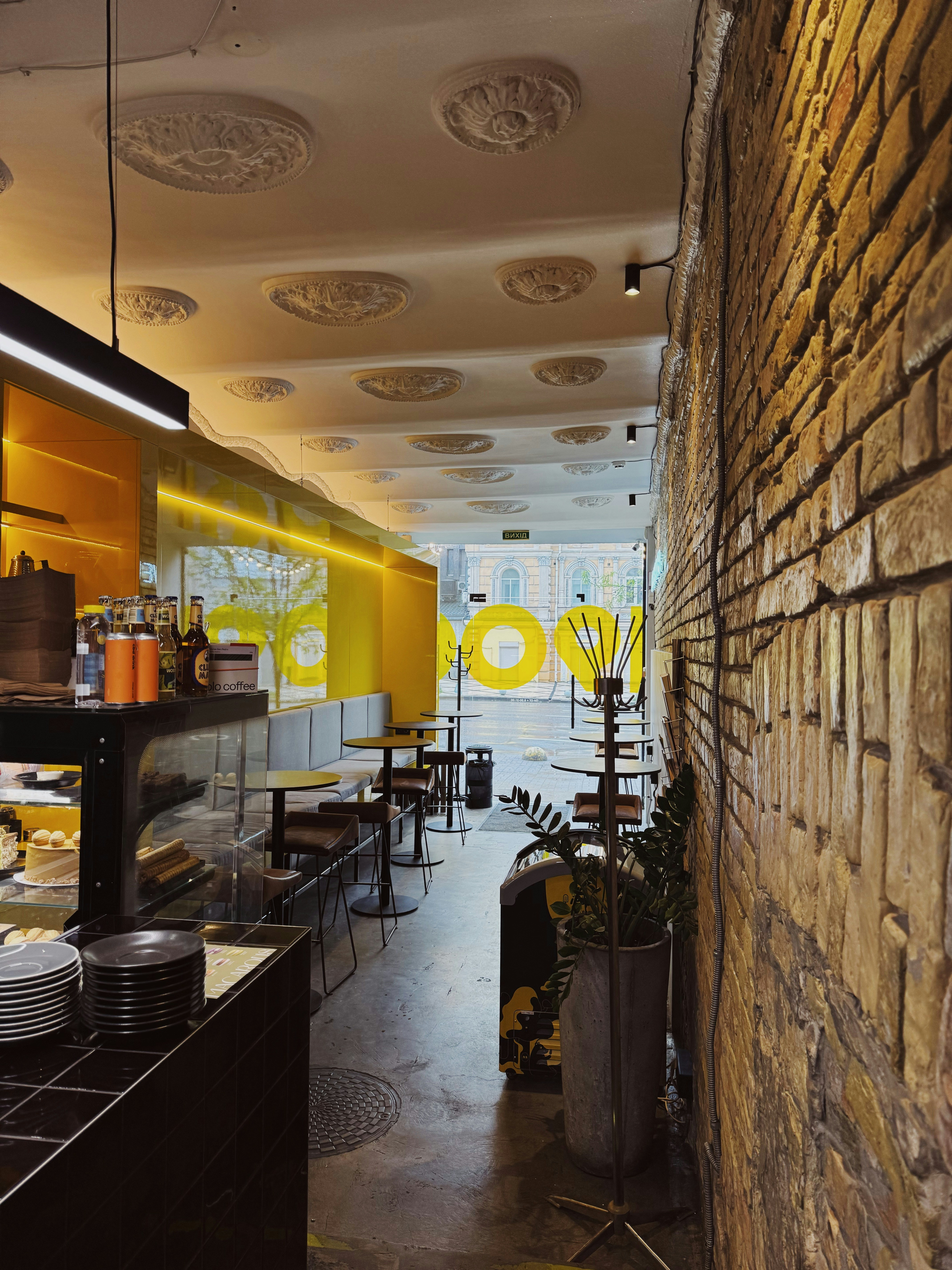 Golden Logo at the End of a Brick-Walled Café Corridor