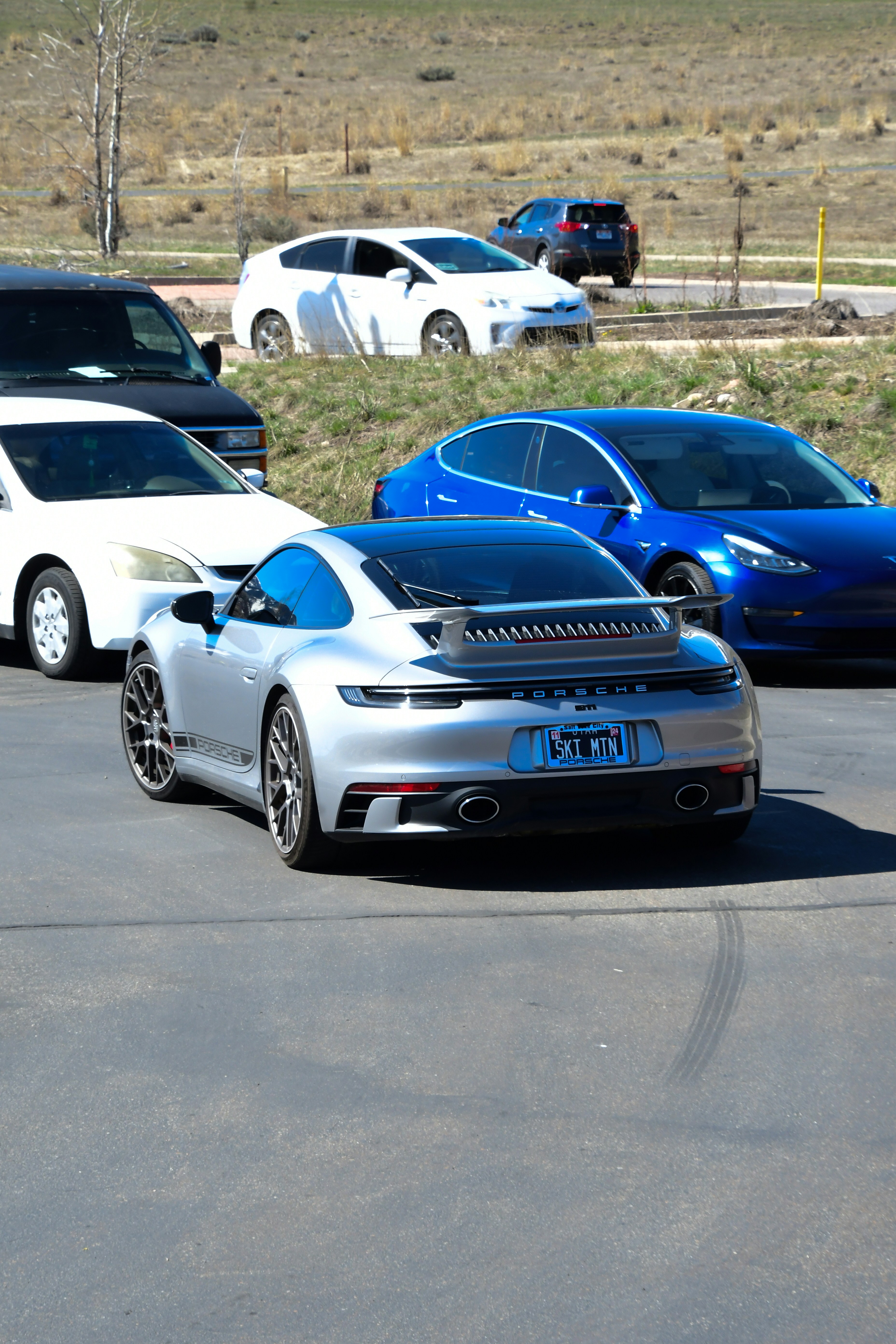 Sleek Silver Porsche 911 Anchors a Sunlit Parking Row