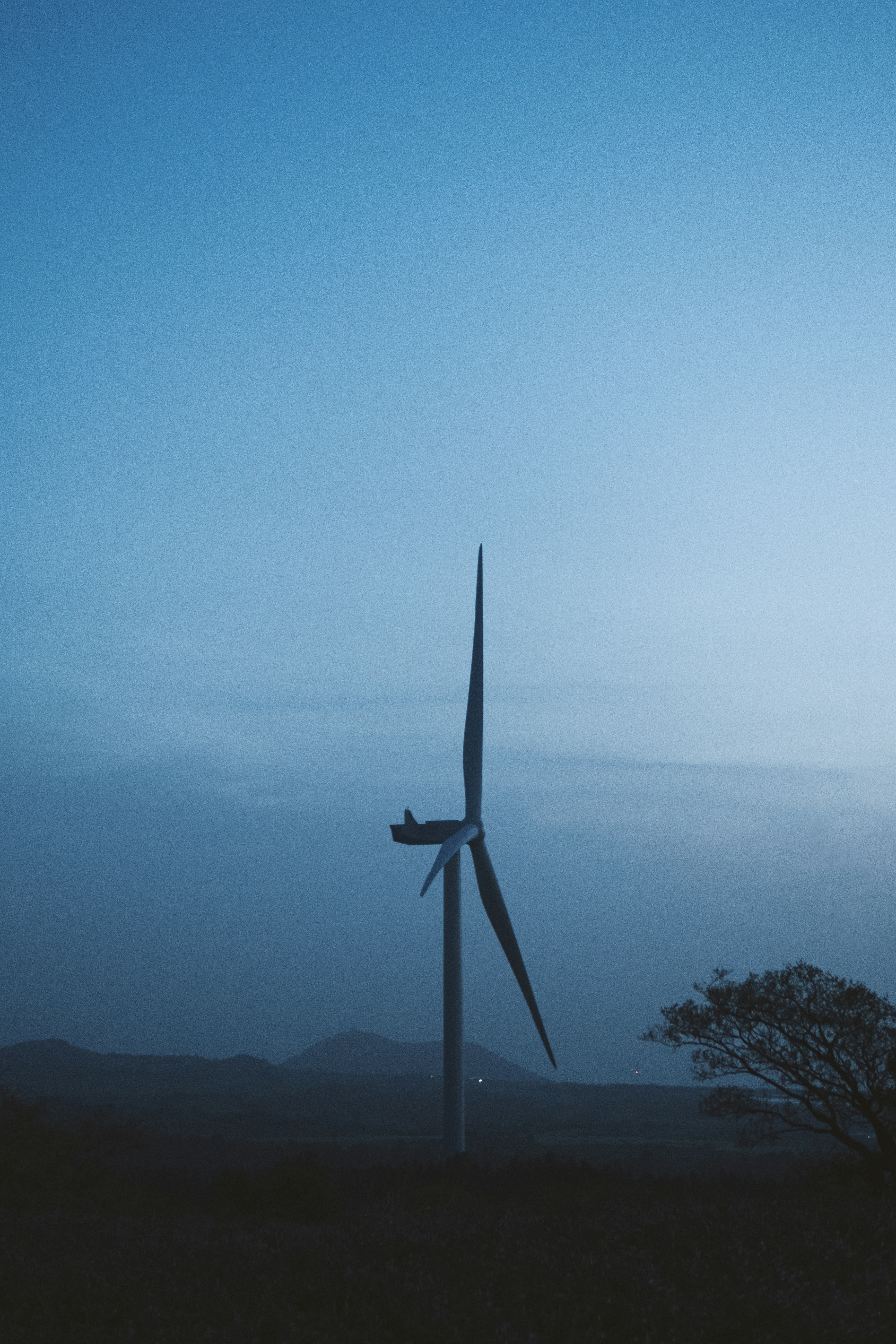 Dusk Quiet: A Lone Wind Turbine Against a Pale-blue Horizon