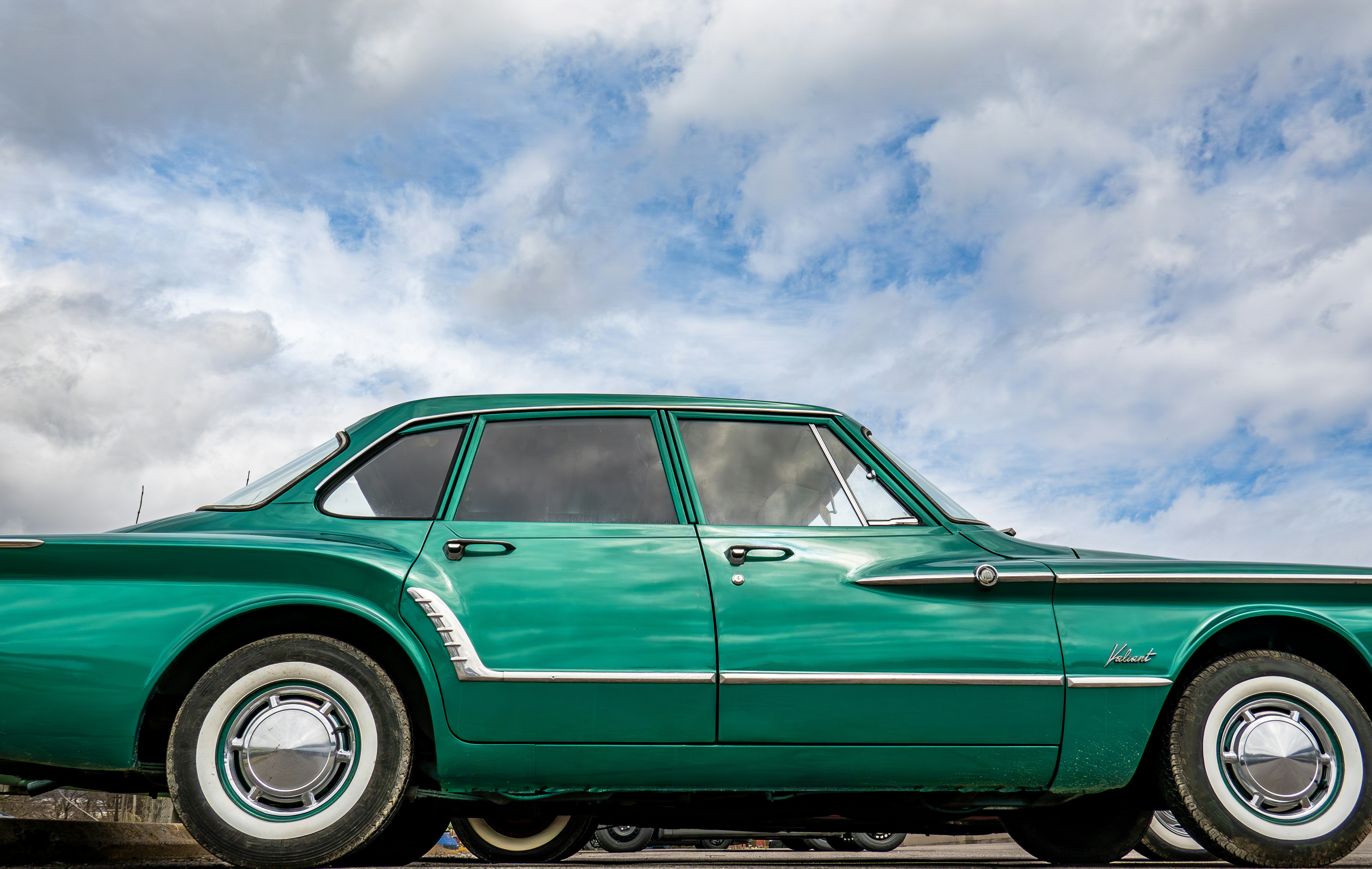 Teal Mid-Century Sedan Against a Sky-Framed Horizon