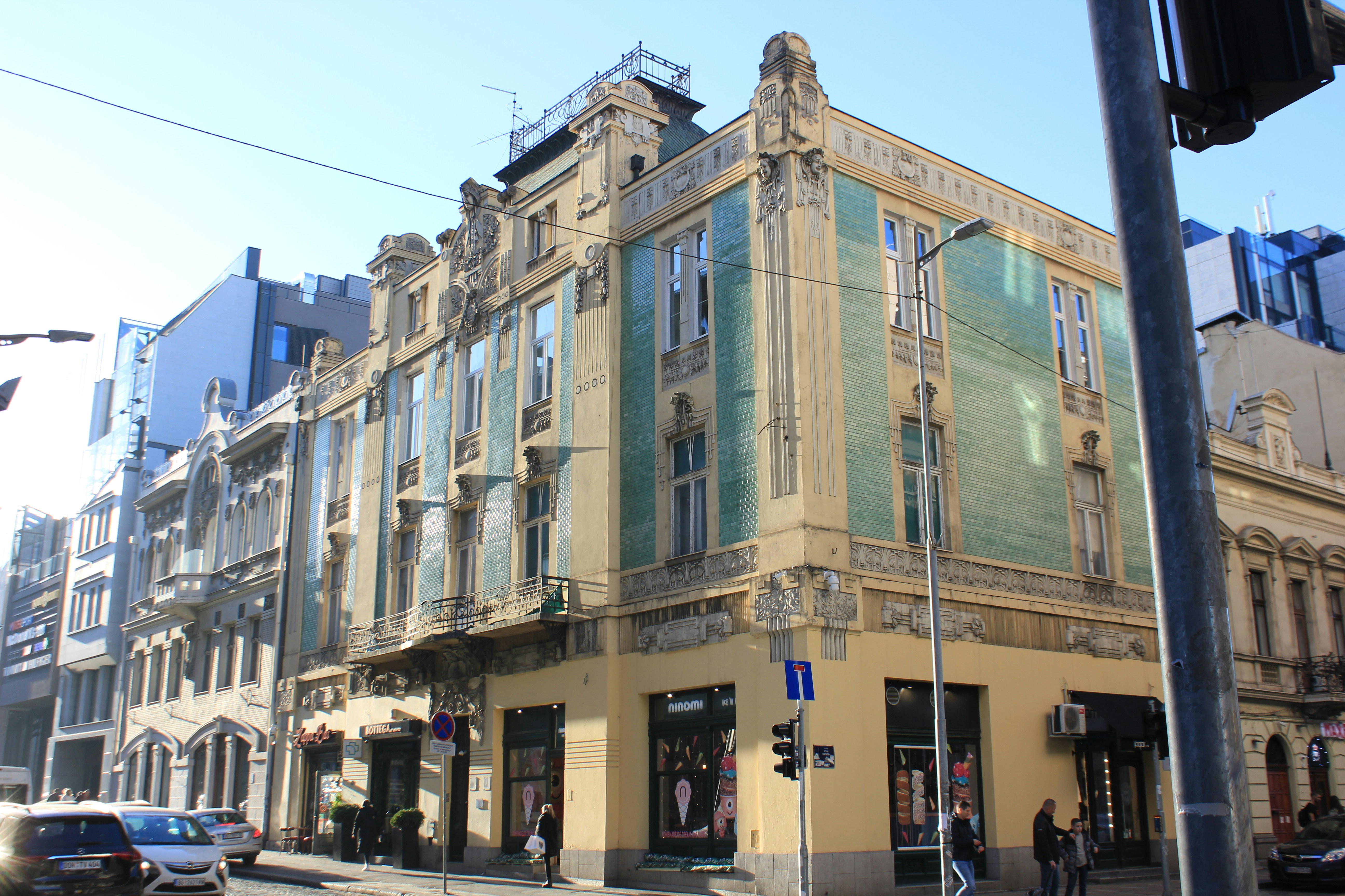 Sunlit Beaux-Arts Corner on a Bustling City Block